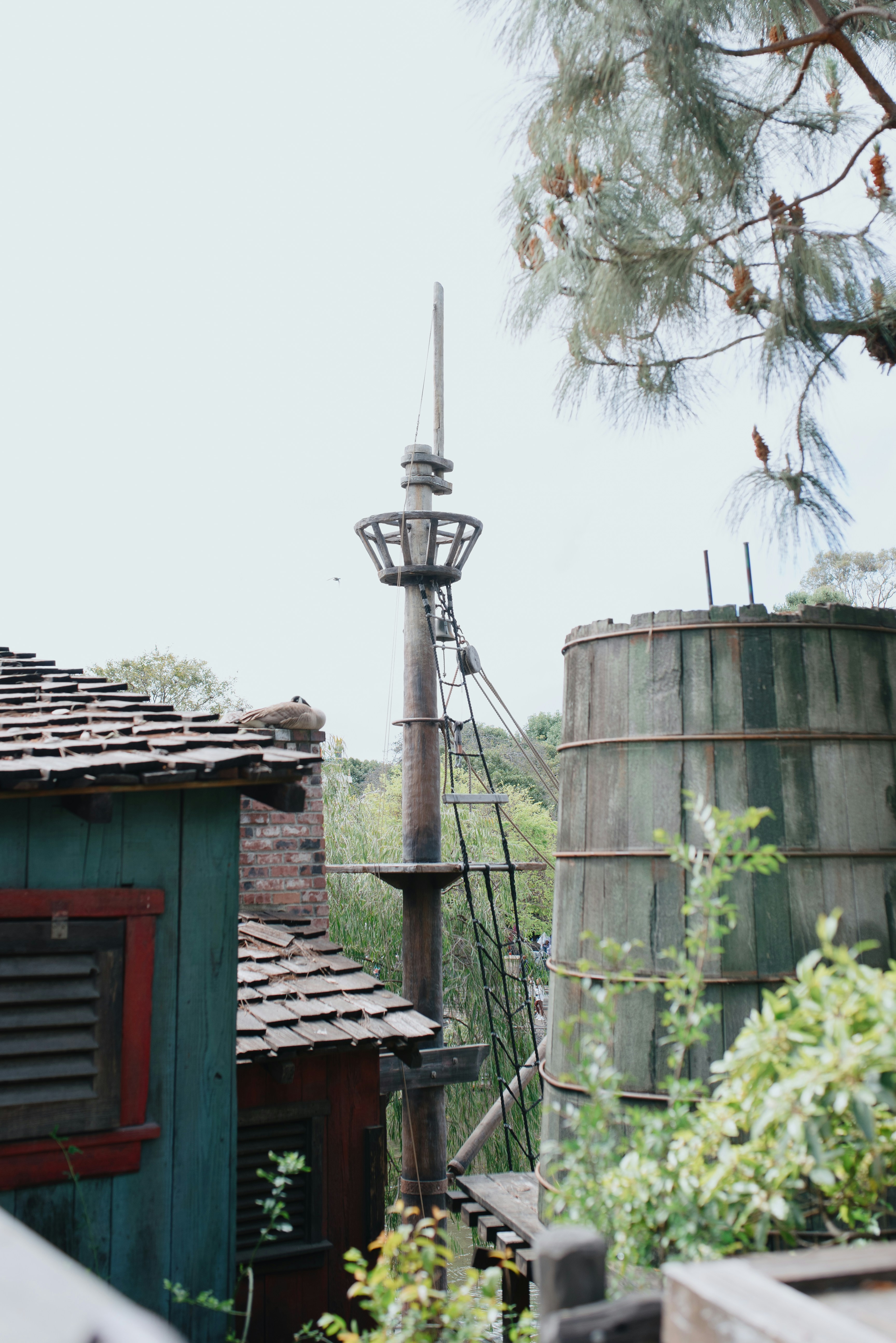 Industrial spire and water tank set against a rustic neighborhood