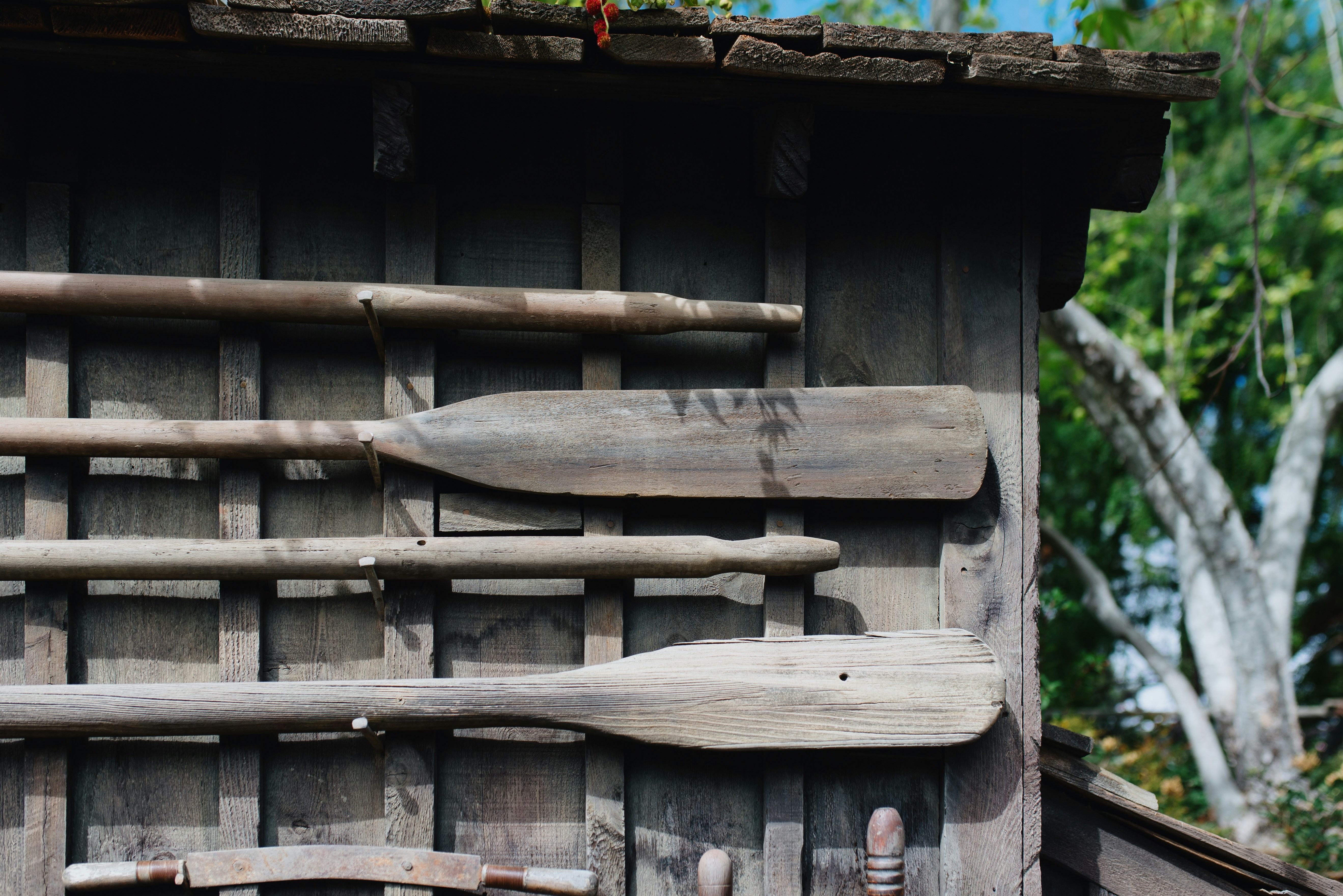 Weathered Tools on a Rustic Shed: A Quiet Window into Craft and Time