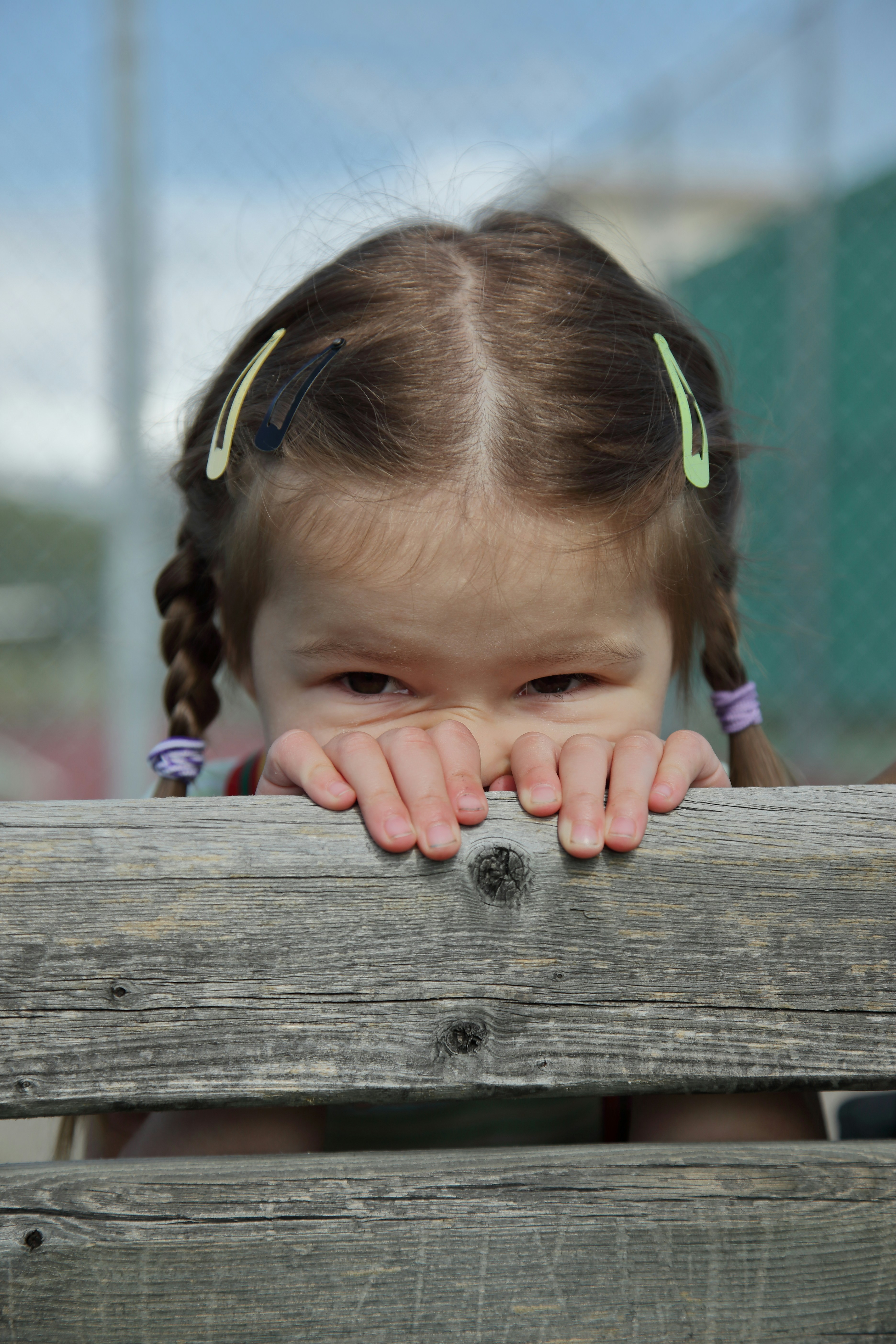 Girl at the Fence: Quiet Playground Mischief