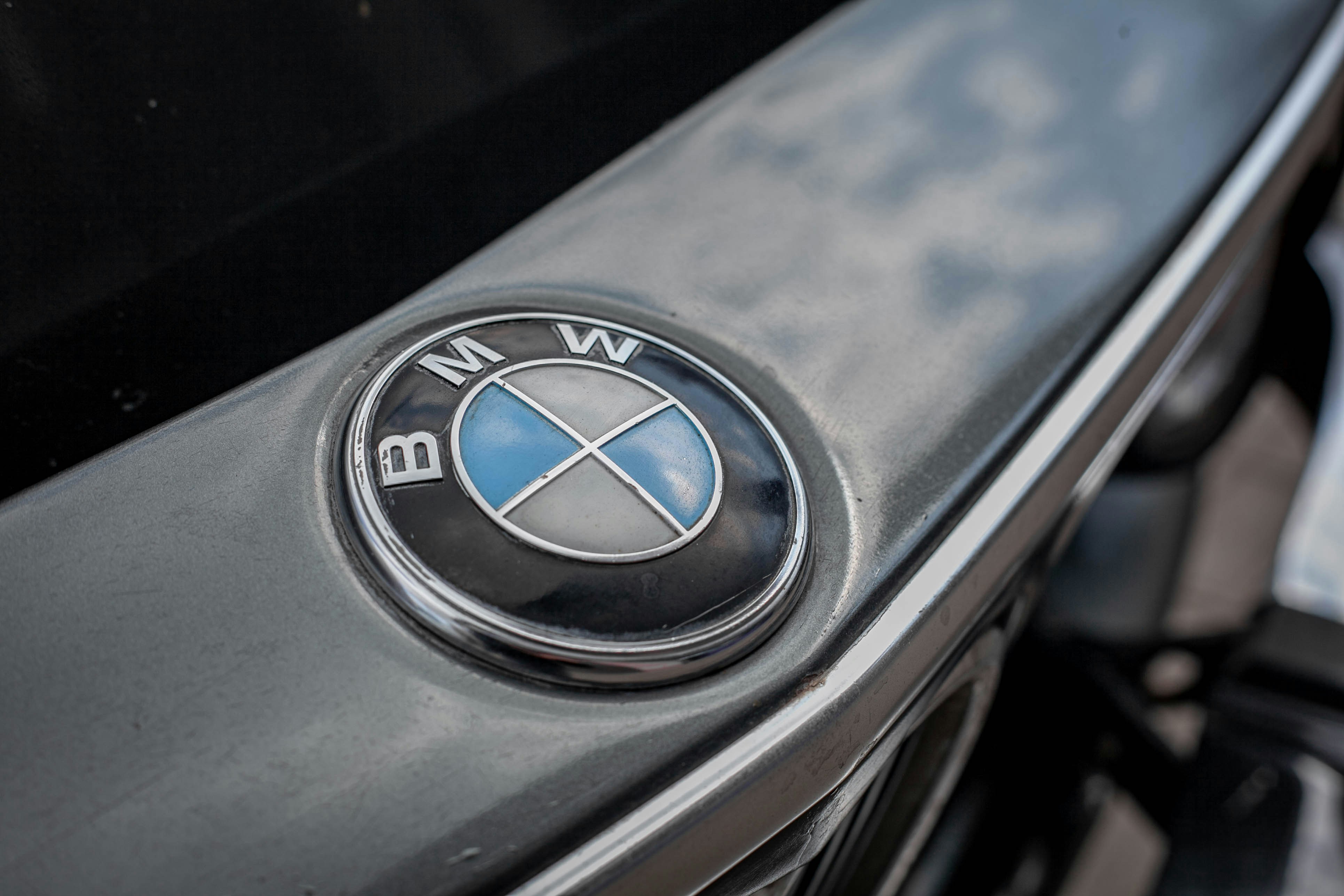 Emblem at the Core: BMW Badge on a Weathered Hood