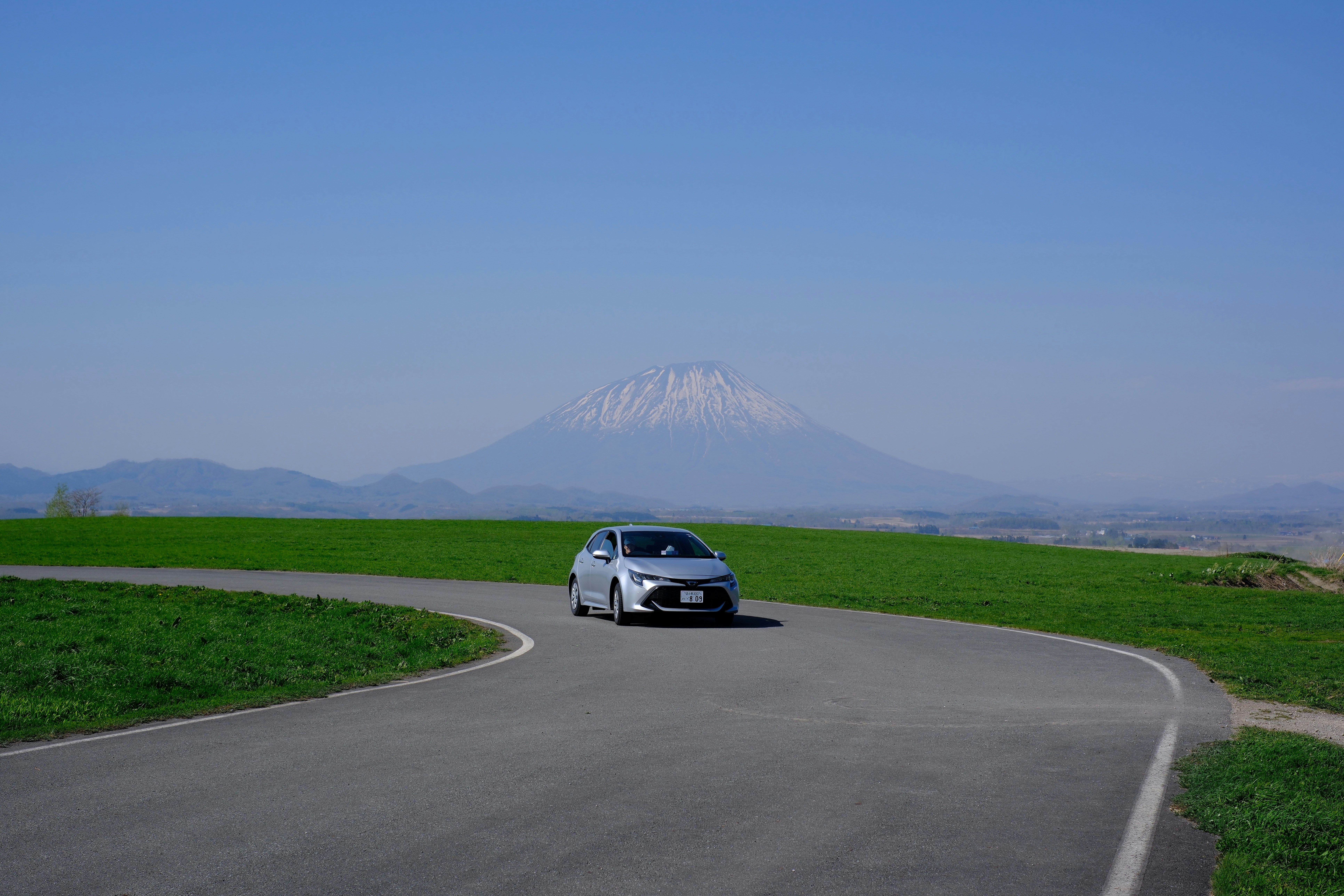 Silver Sedan Gliding Along the Mountain Rim