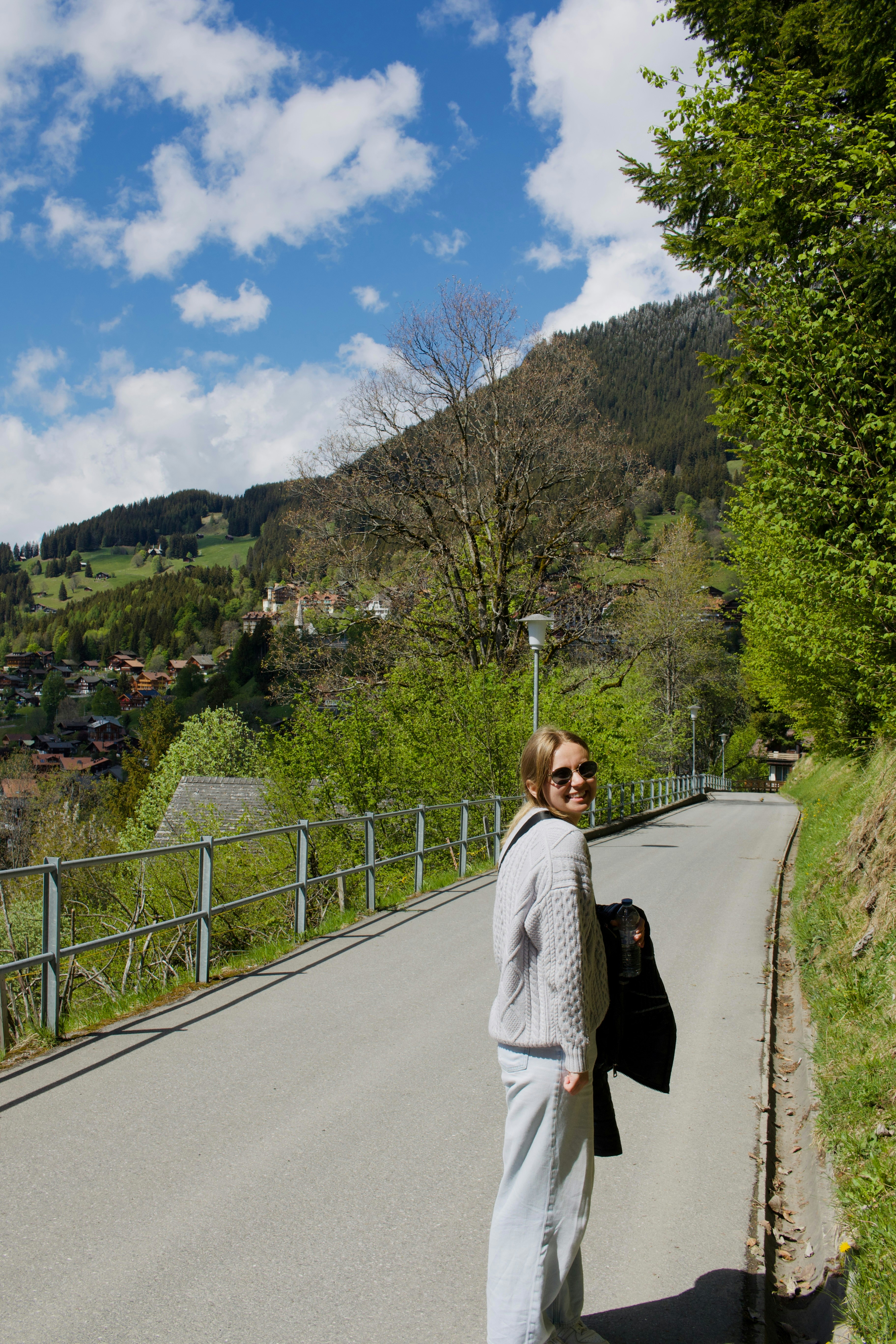 Sunlit Stroll: A Hooded Smile on a Mountain Road