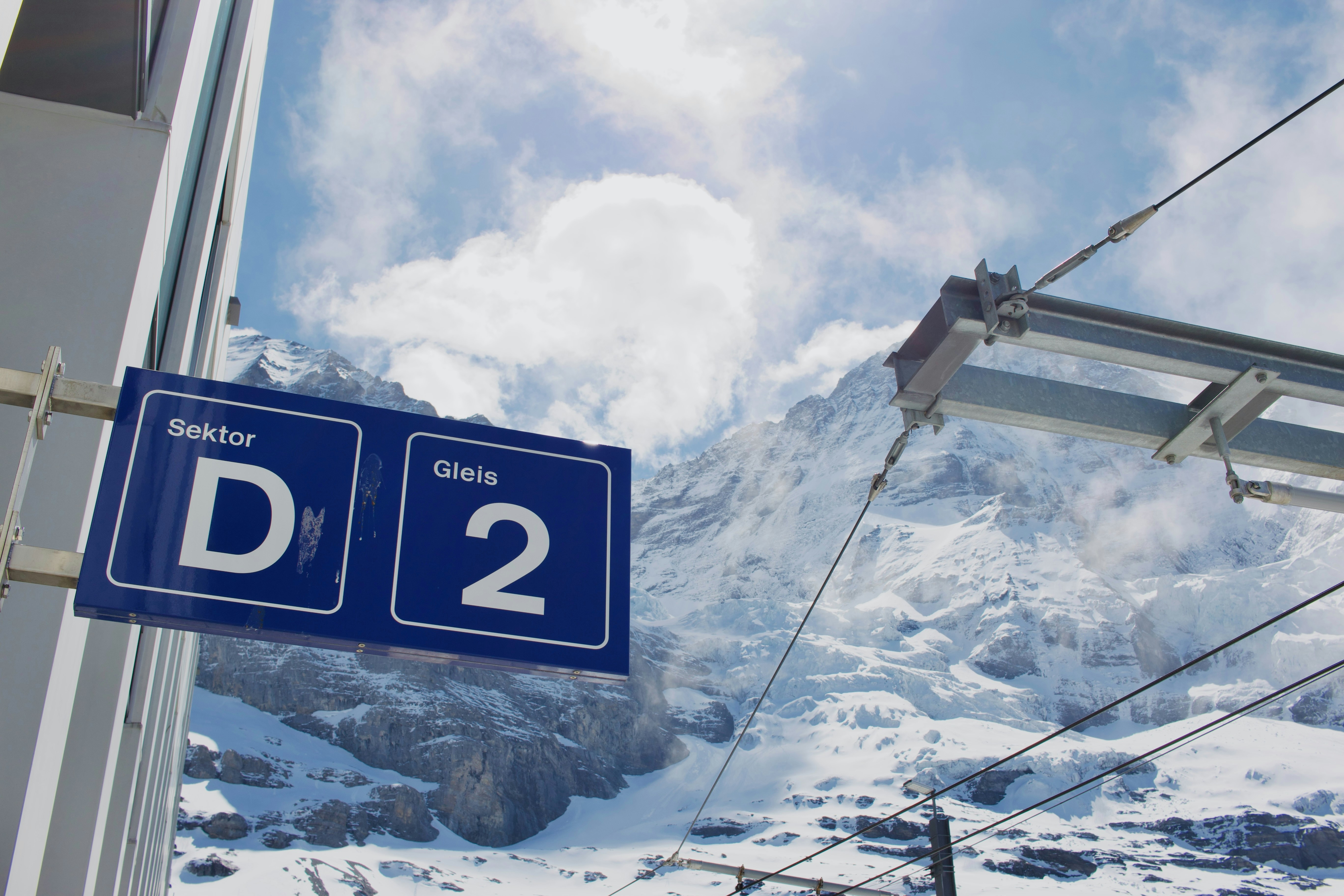 Blue Signpost Between Alpine Slopes