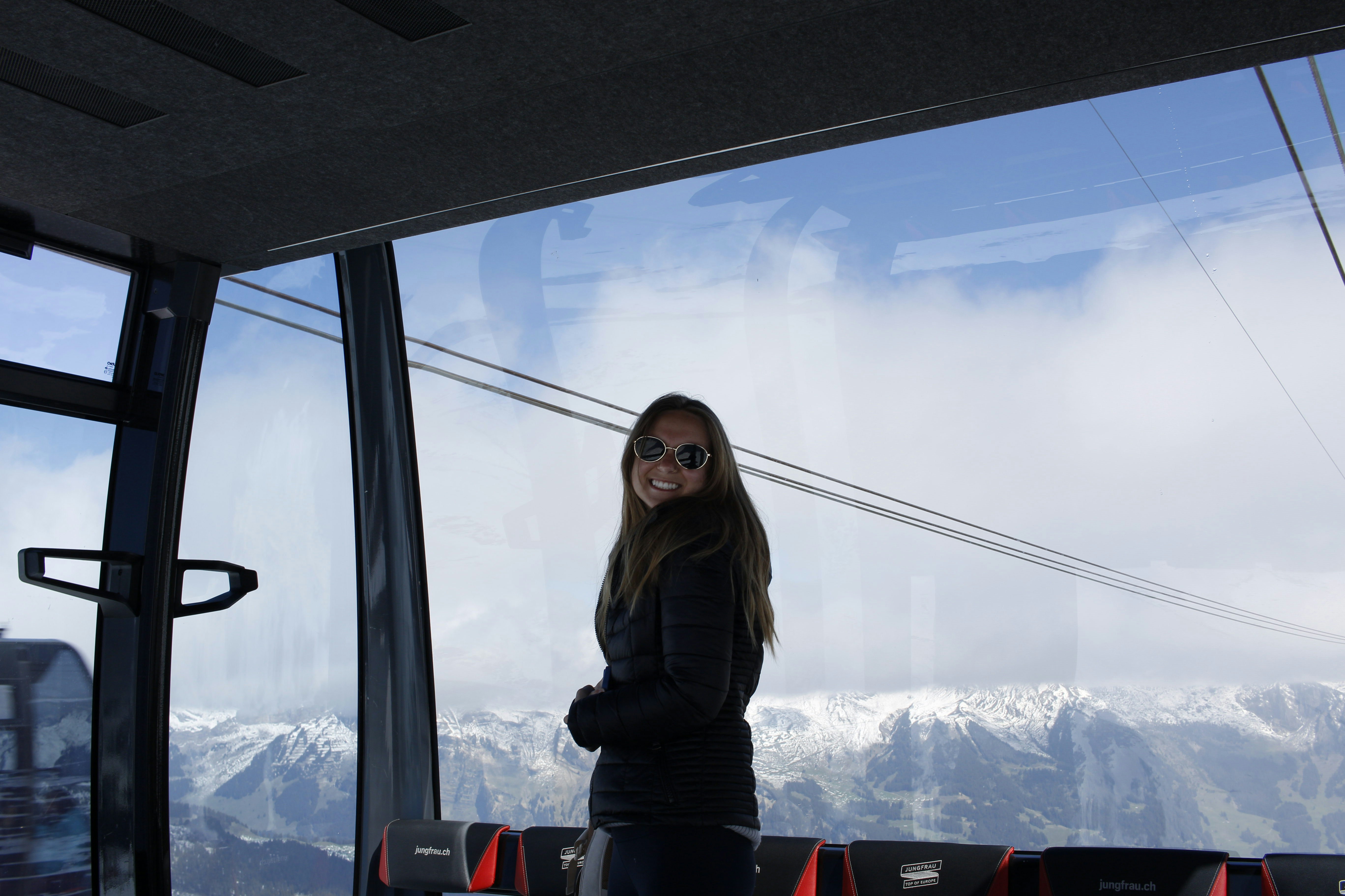 Smiling passenger on a panoramic gondola ride with snow-capped peaks