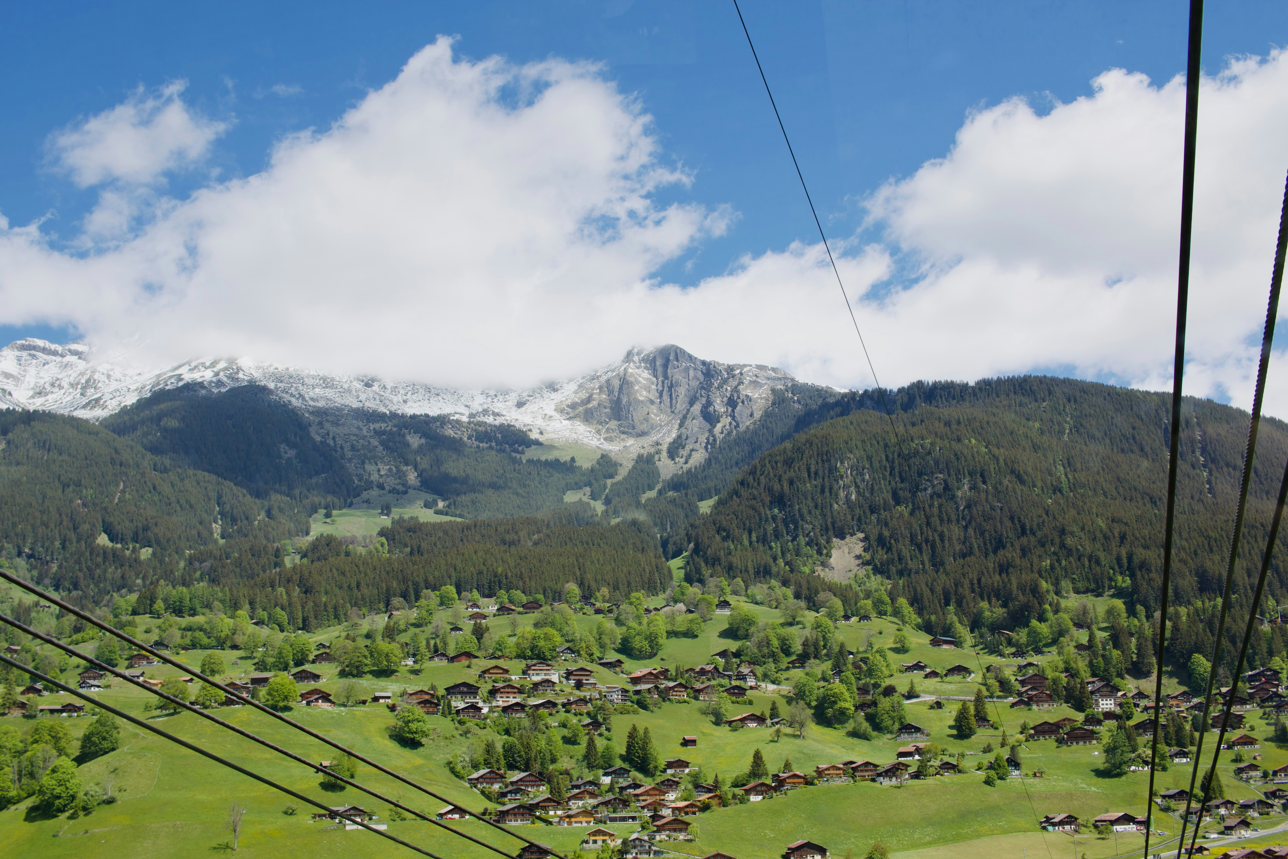 Alpine Village Under Snow-Kissed Peaks from a Cable-Car Vista