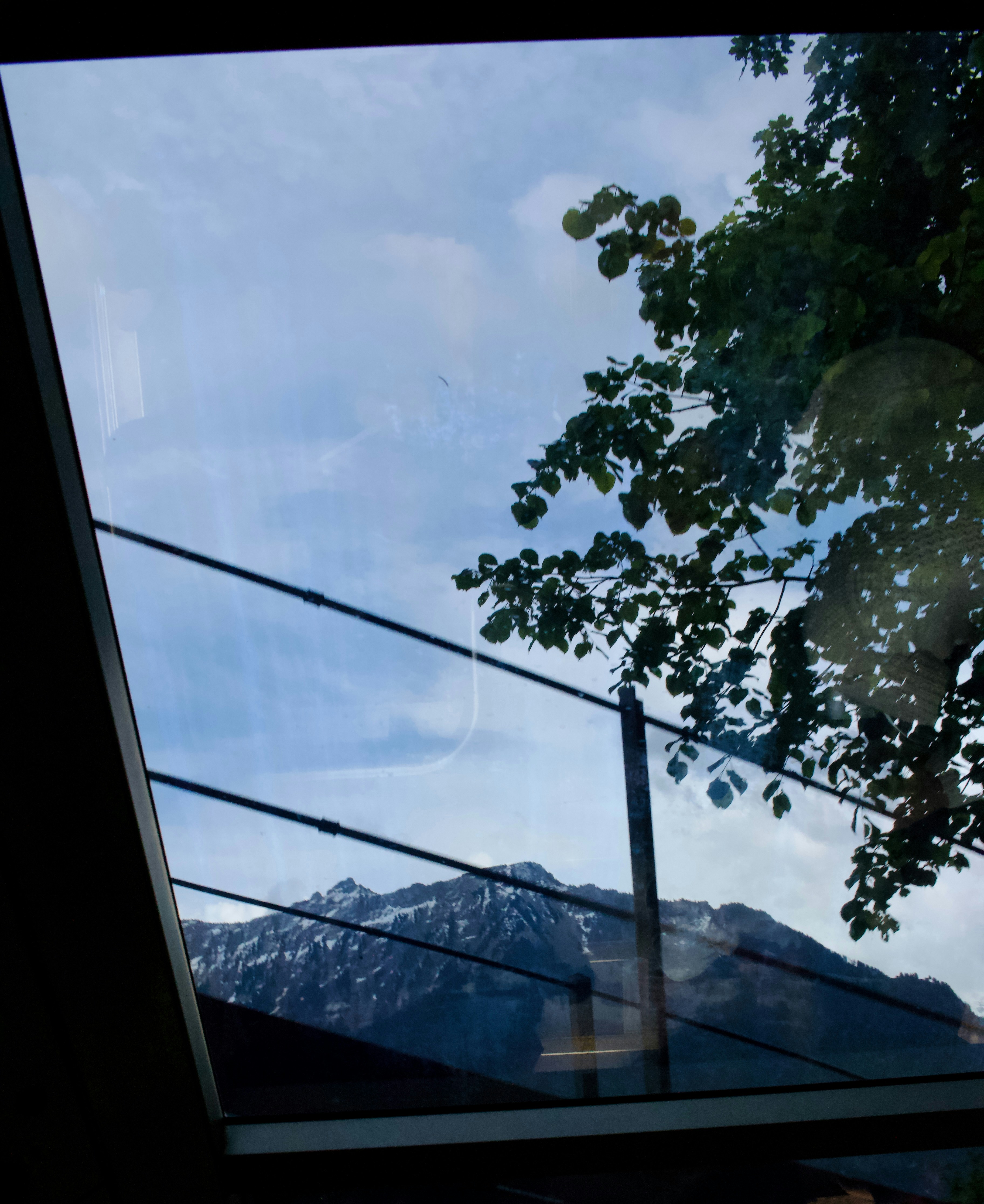 Panels of Sky and Peaks: A Quiet View Through a Slanted Window