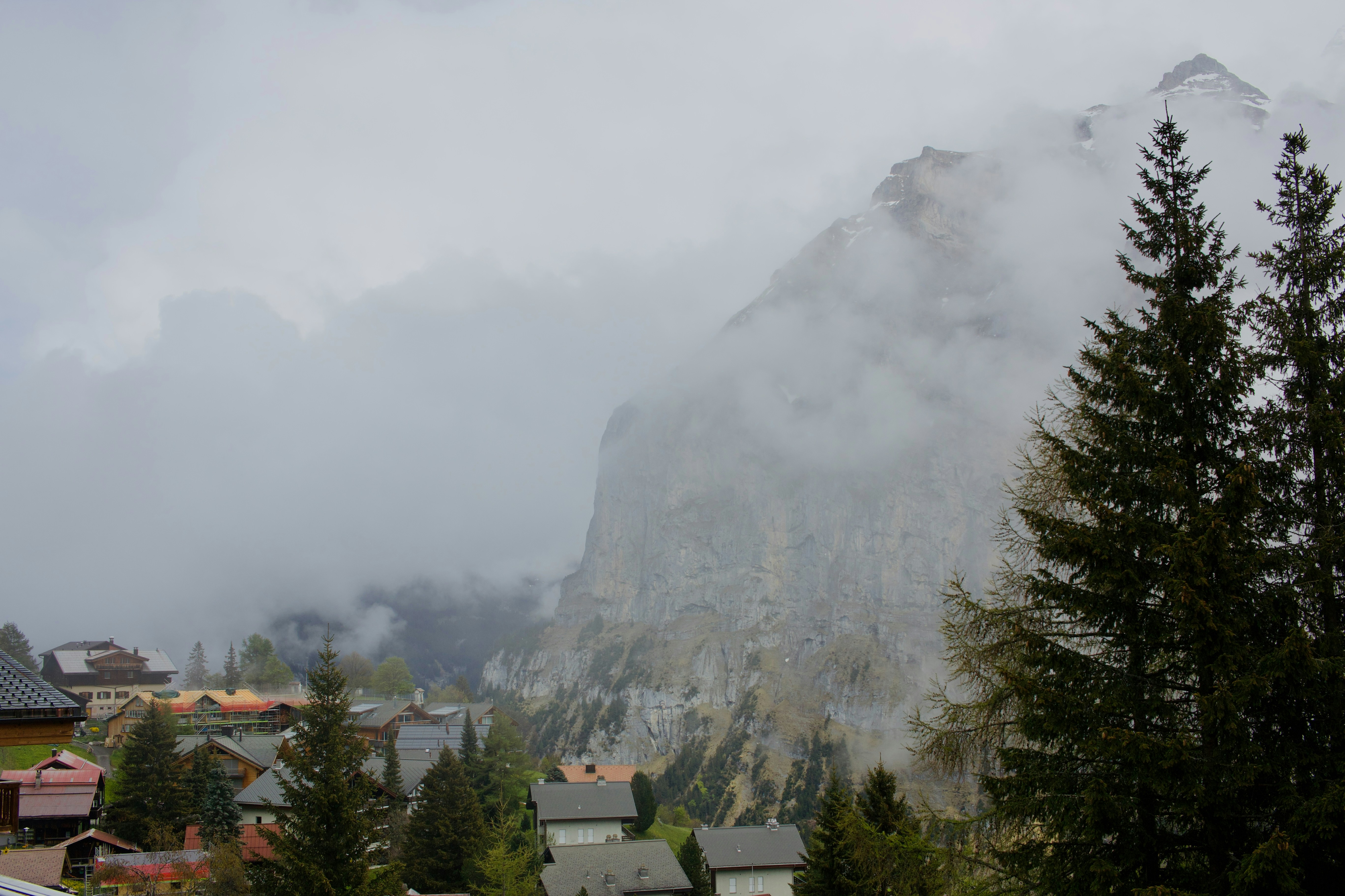 Mist-Laced Village at the Foot of a Shrouded Peak