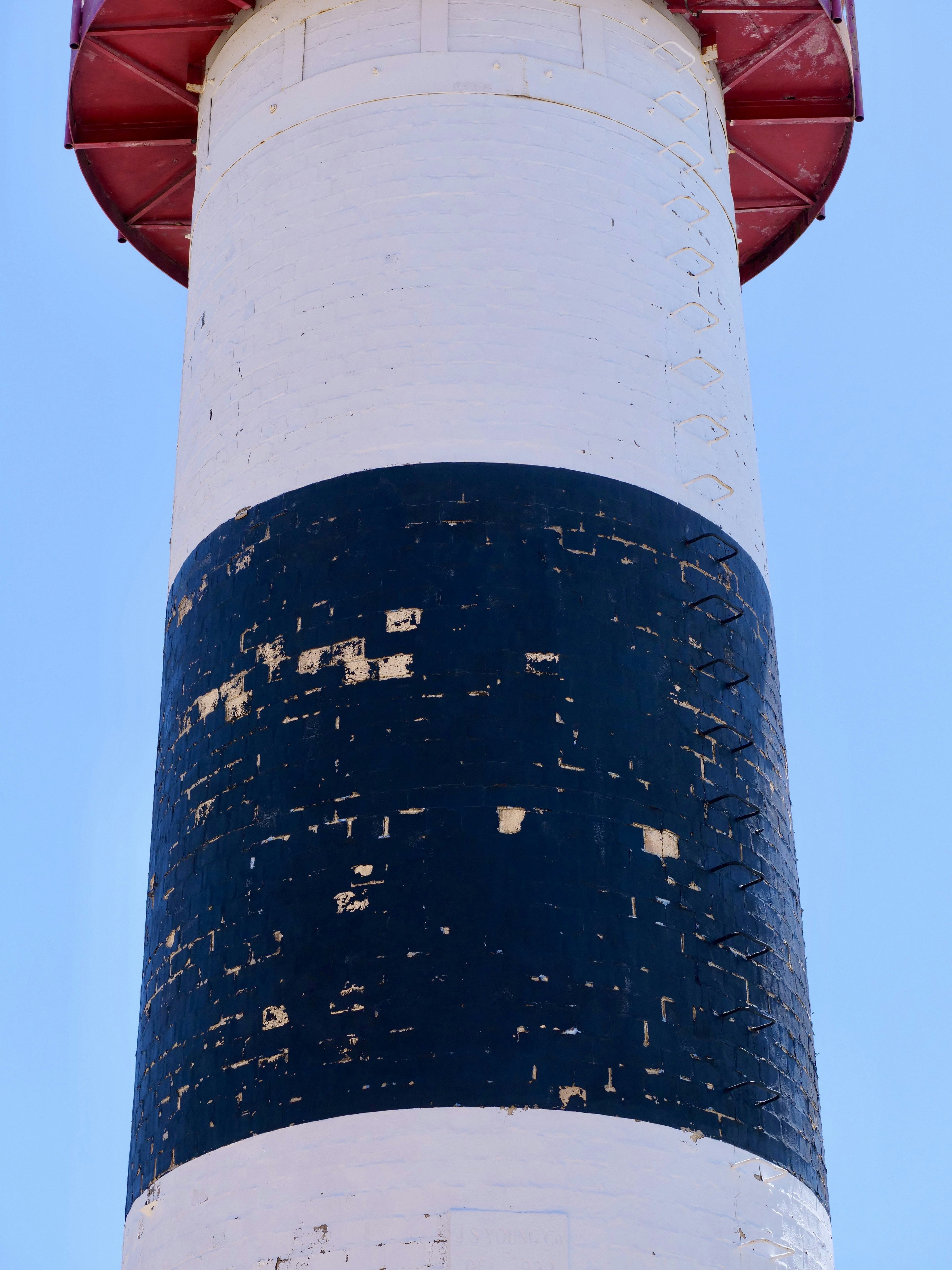 Lighthouse Trunk: A Weathered Beacon Against a Clear Blue Sky