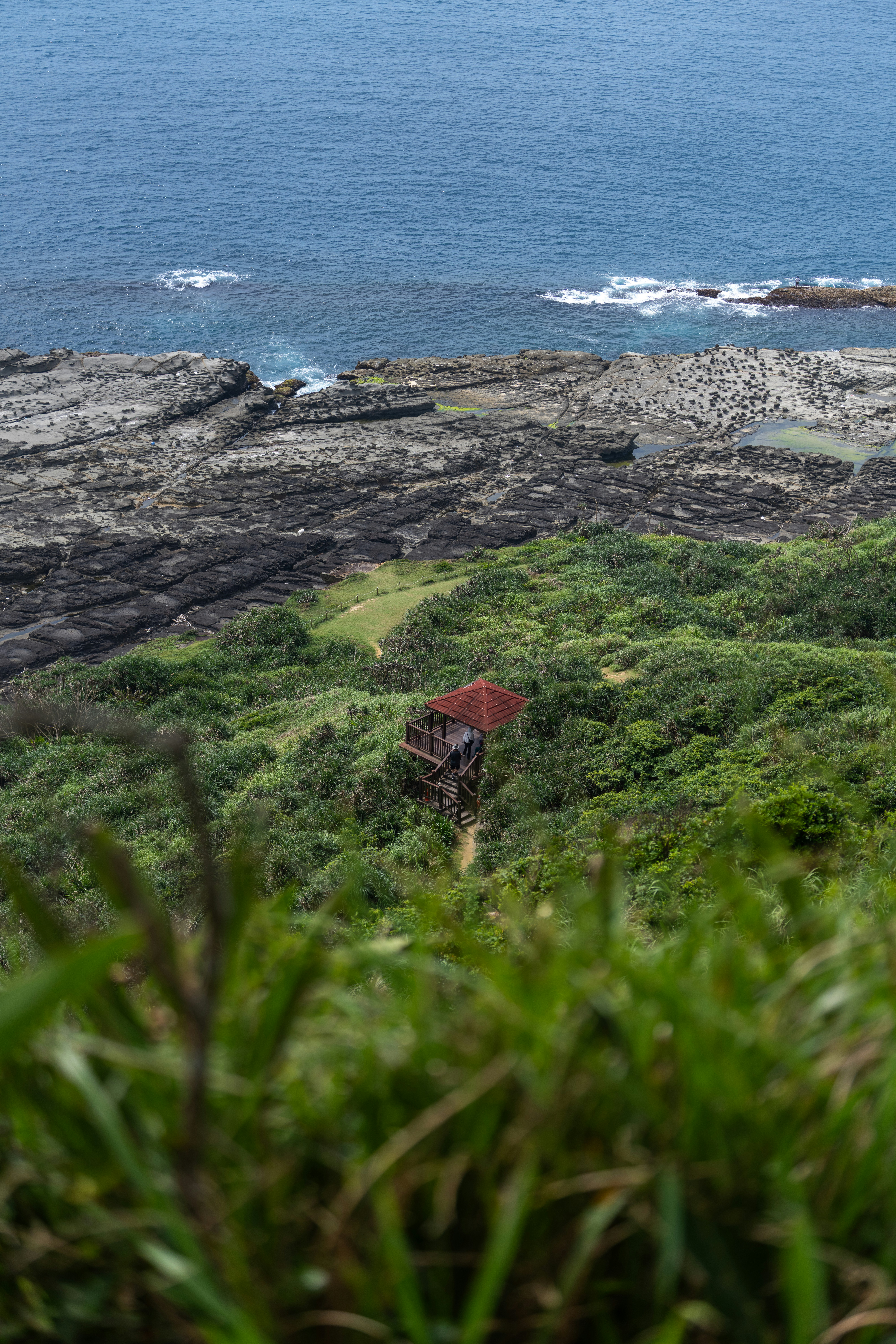 Red-roofed viewing hut perched above rocky shoreline