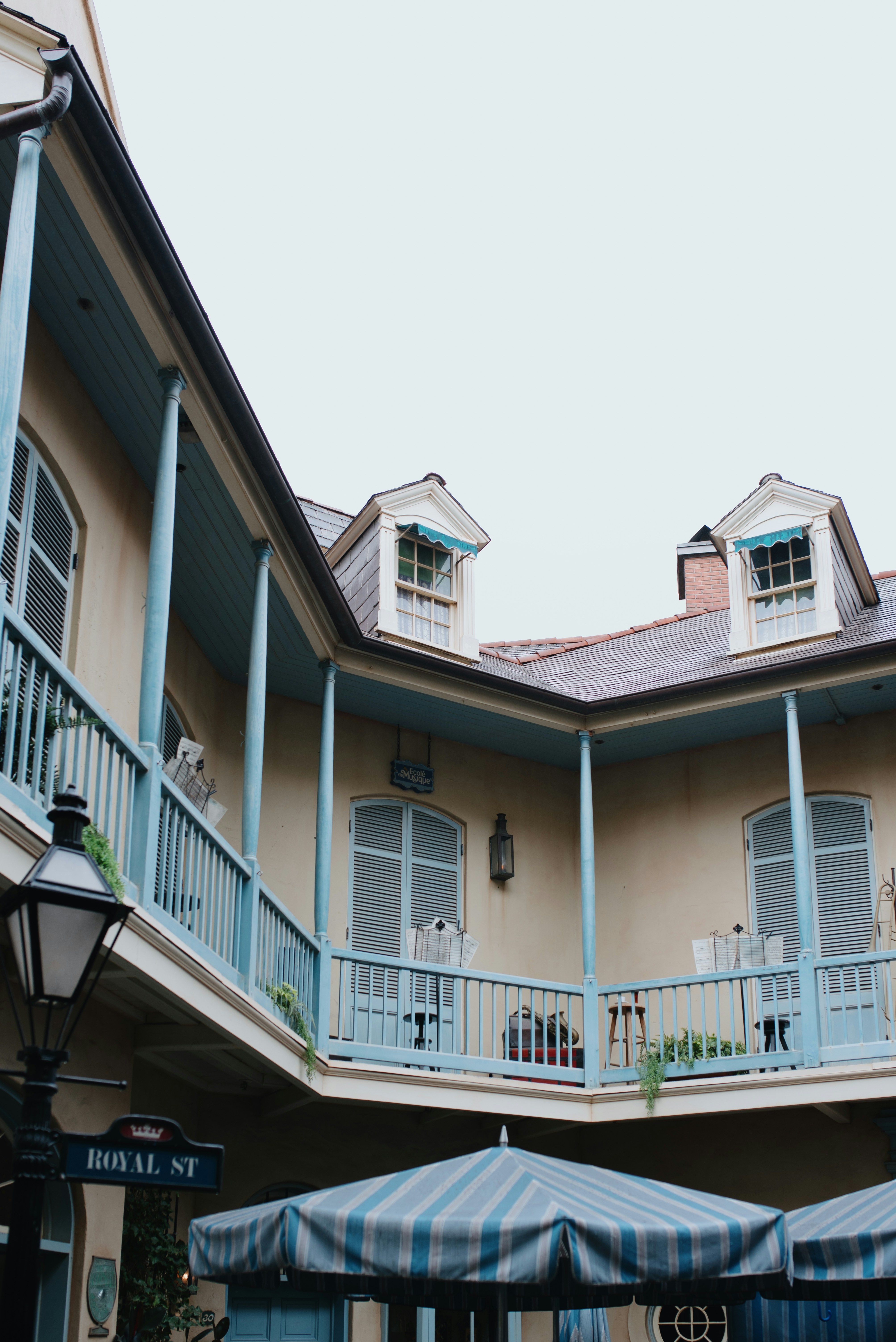 Courtyard Colonnade: Blue Railings and Dormer Windows Above Royal Street