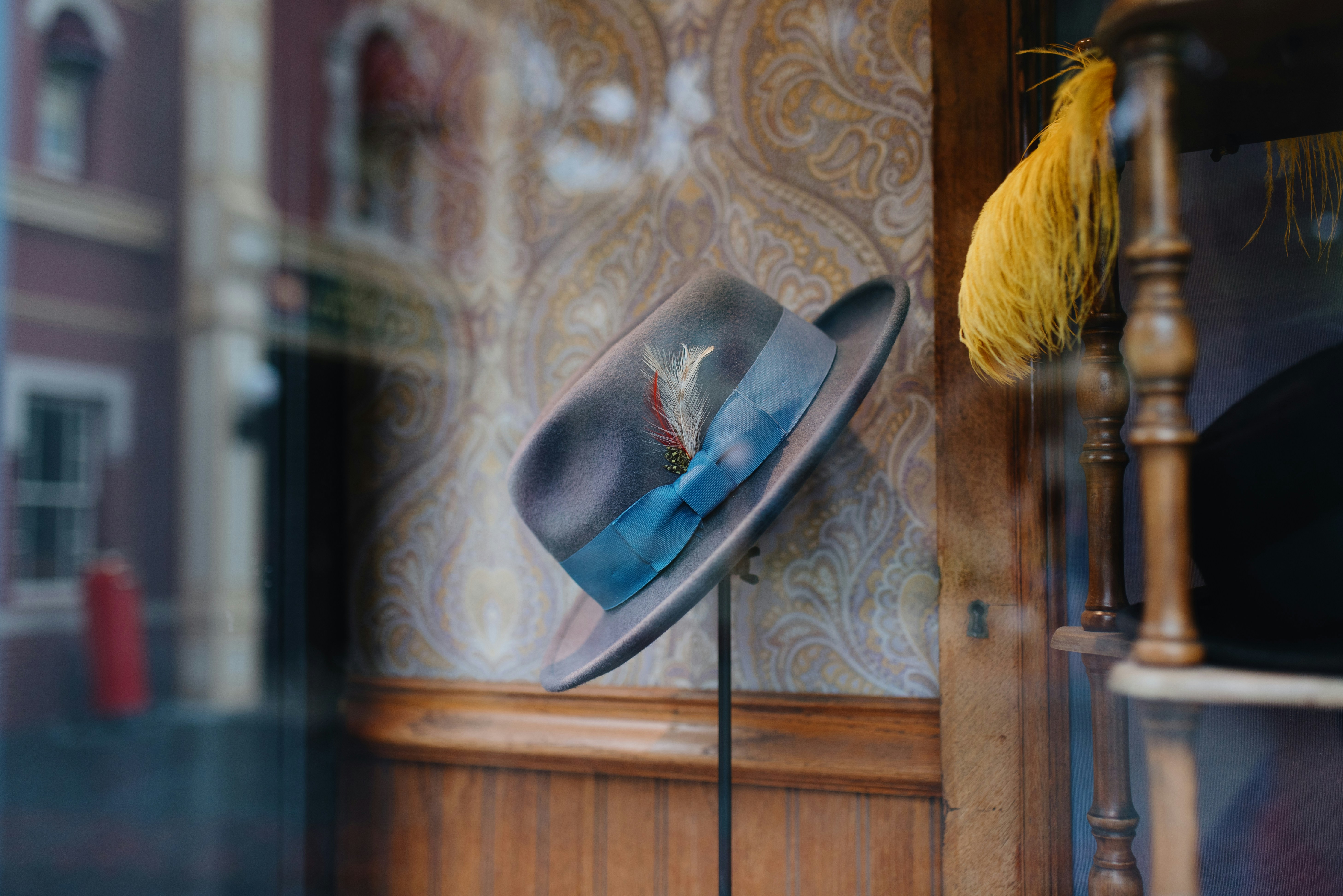 Hat on a Tilted Stage: A Quiet Display in Vintage Wood and Wallpaper