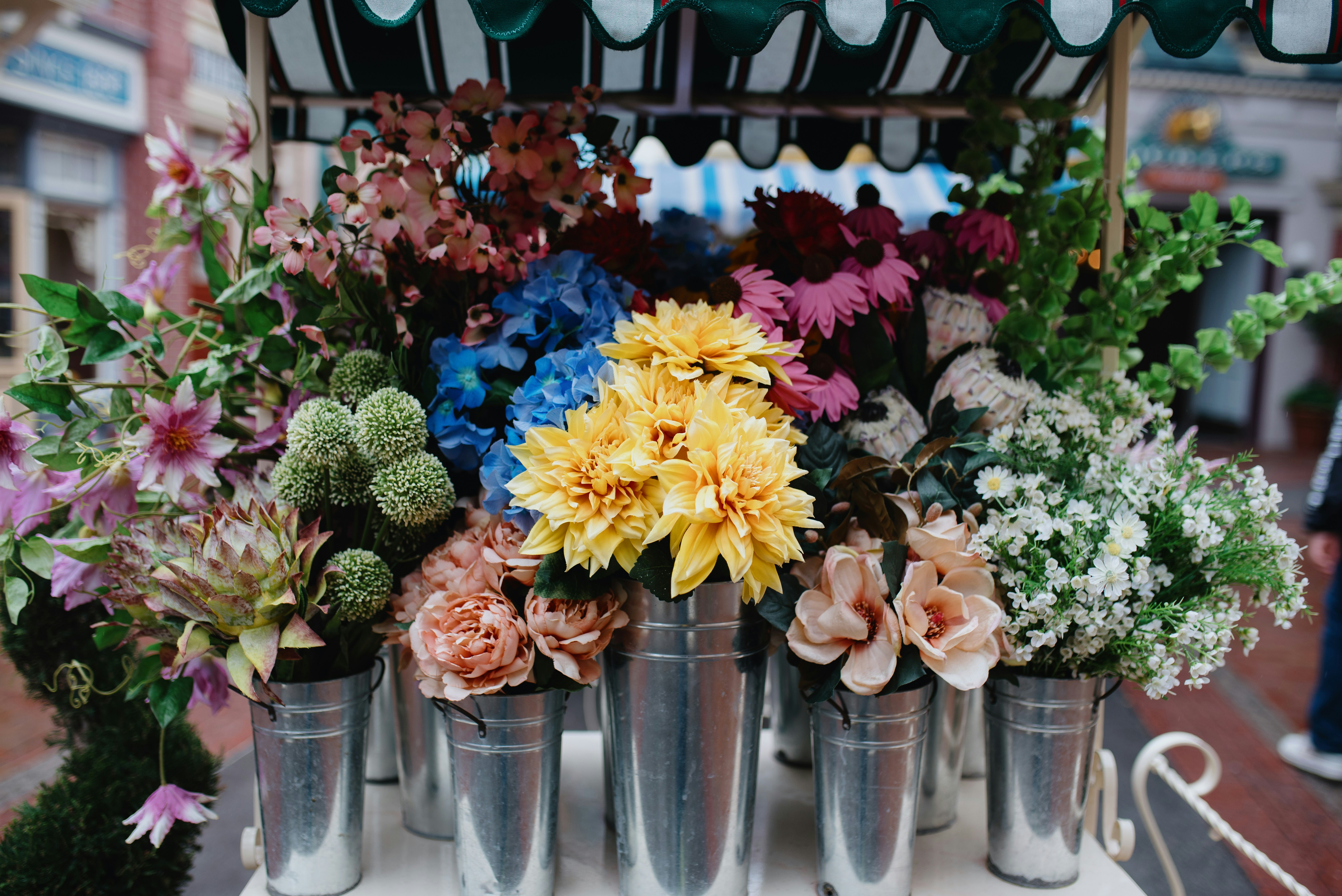 Bouquet Row: Colorful Metal Pots Under a Market Canopy