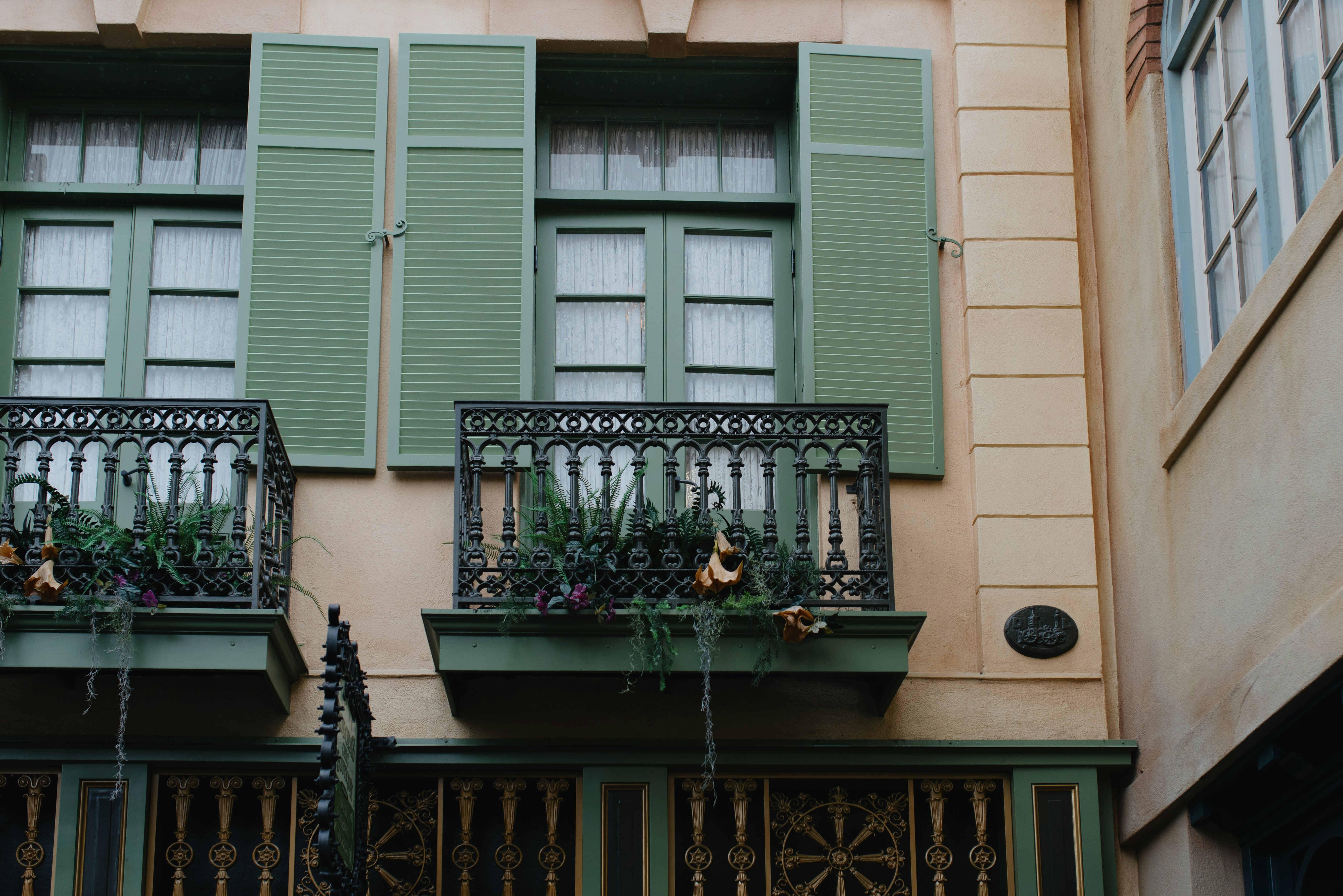 Green Shuttered Windows and Wrought-iron Balcony Afternoon
