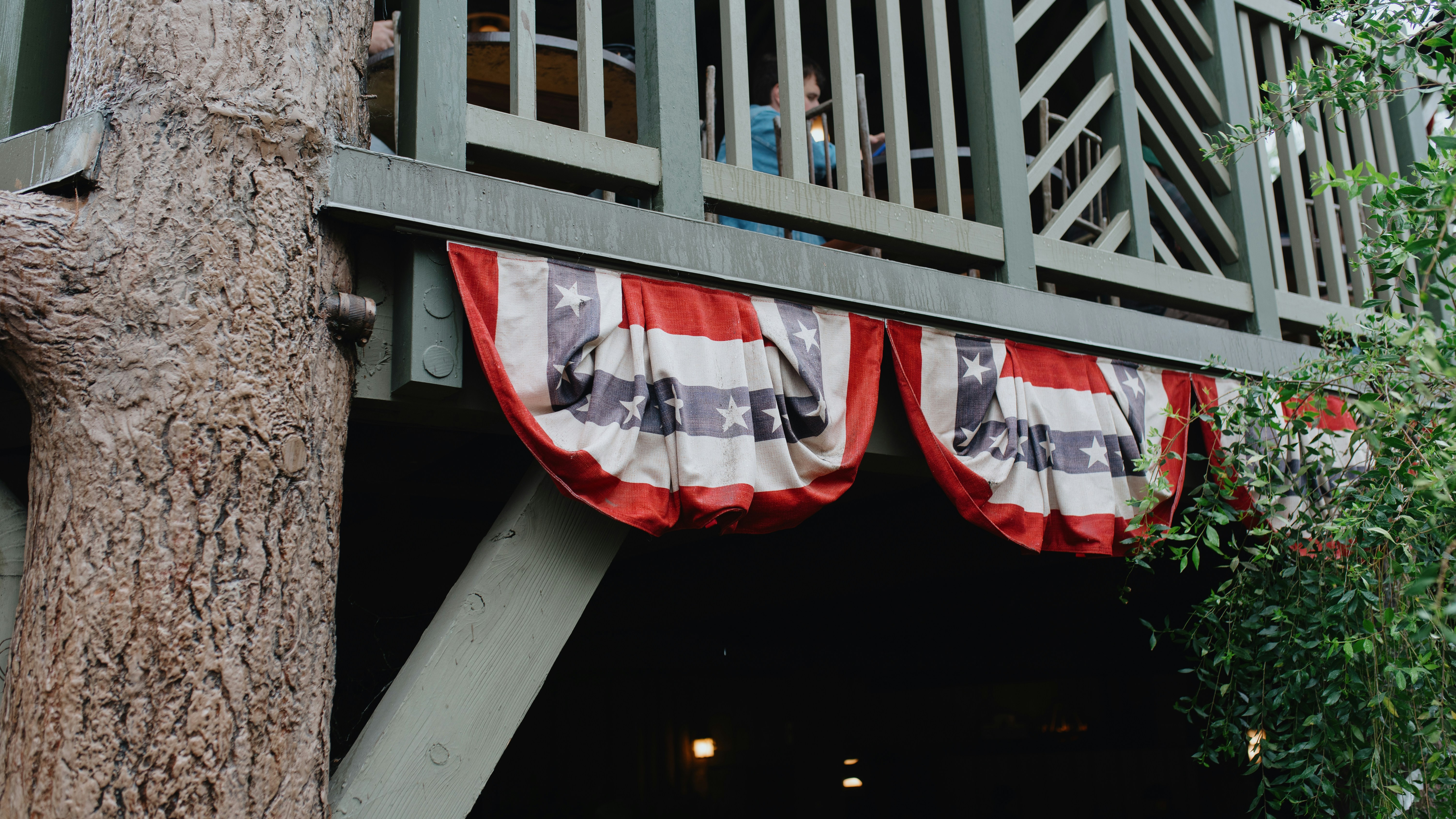 Red, White, and Balcony Rails: Patriotic Drapery Over a Quiet Veranda