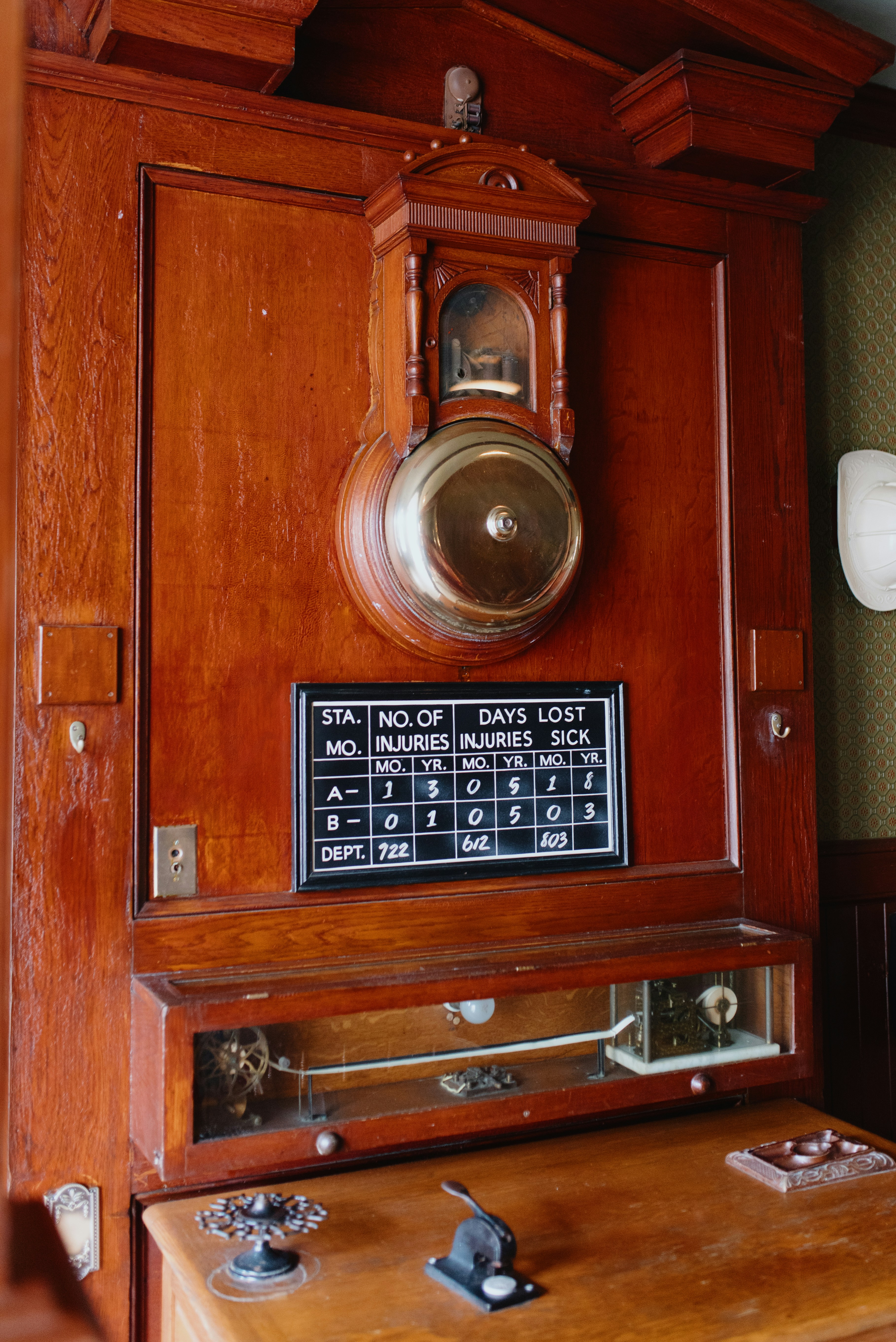 Old-World Timekeeper: A Wooden Wall Clock Guarding a Memorabilia Display