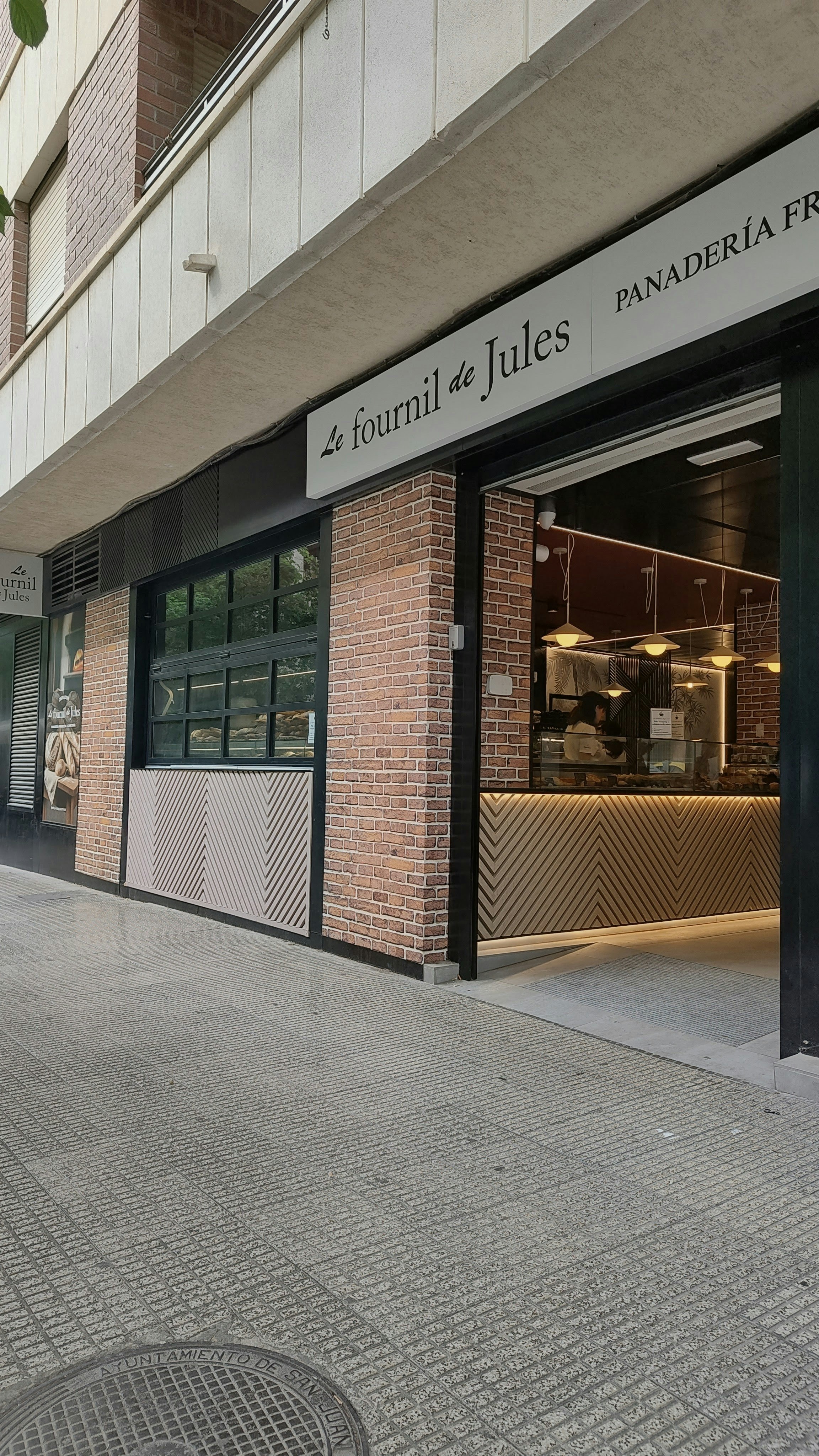 Le Fournil de Jules: Brick Facade Bakery Under Urban Overhang