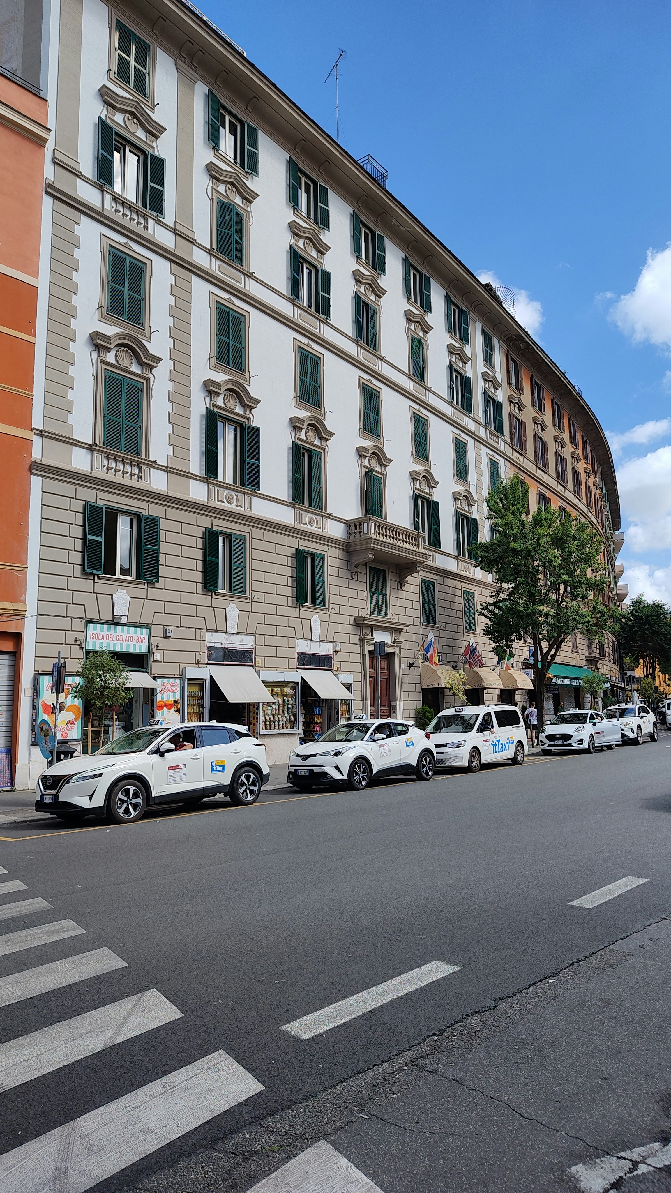 Curved Facade Street Scene with Heritage Building and Parked Taxis