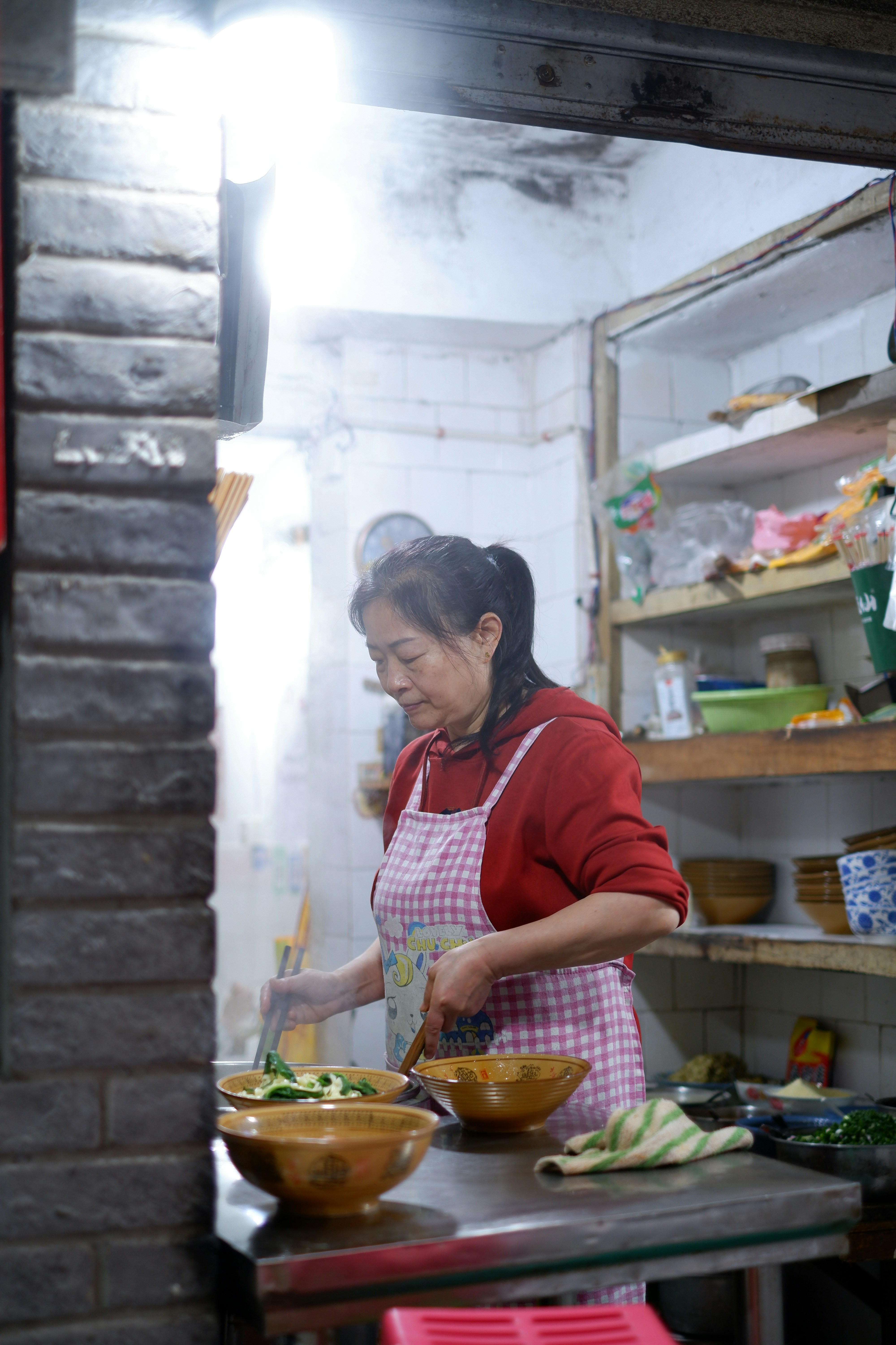 In the Kitchen’s Focus: A Lady Chef Mediating Steam and Plate
