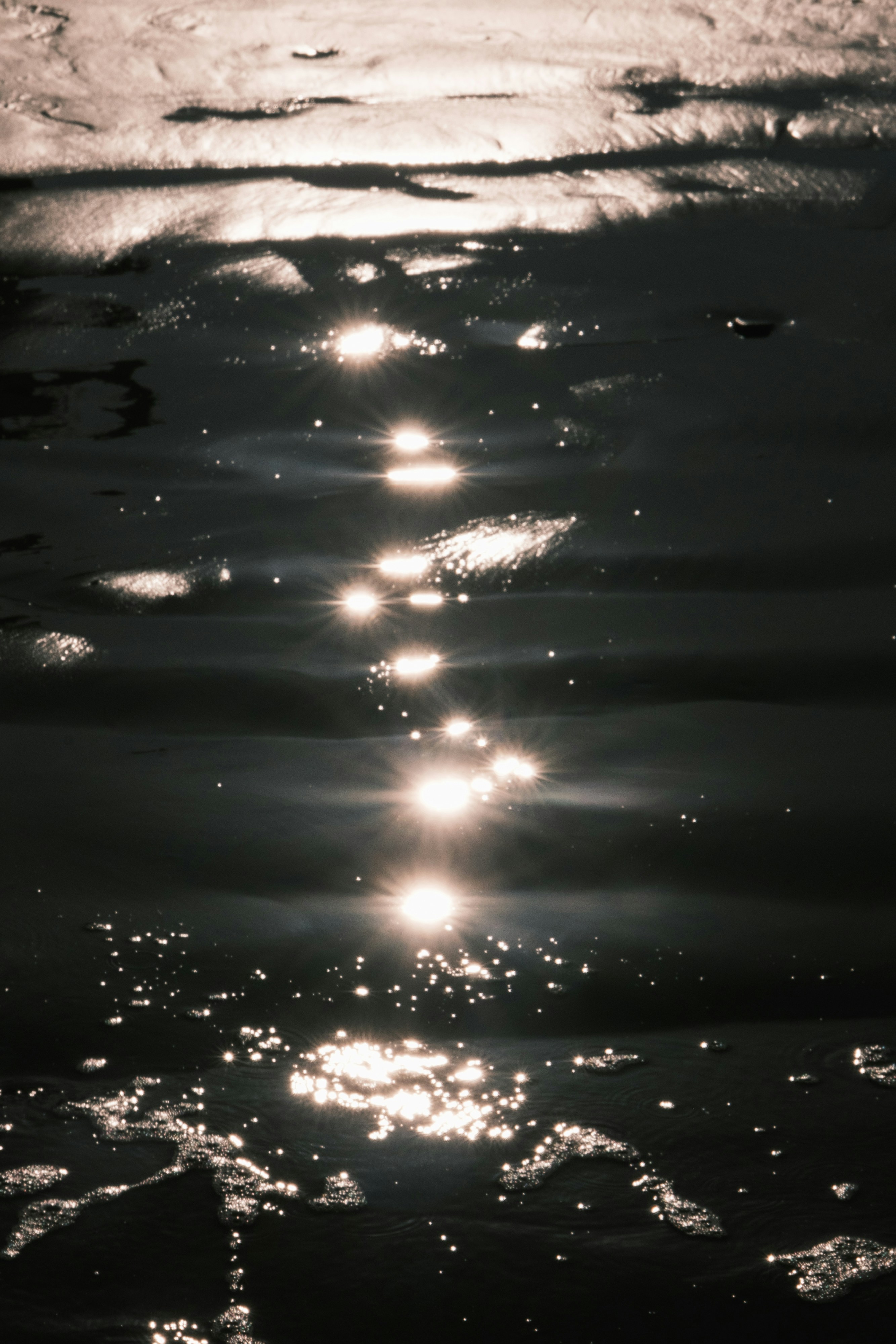 Glistening Ripples: Sunlit Diamonds on Dark Water