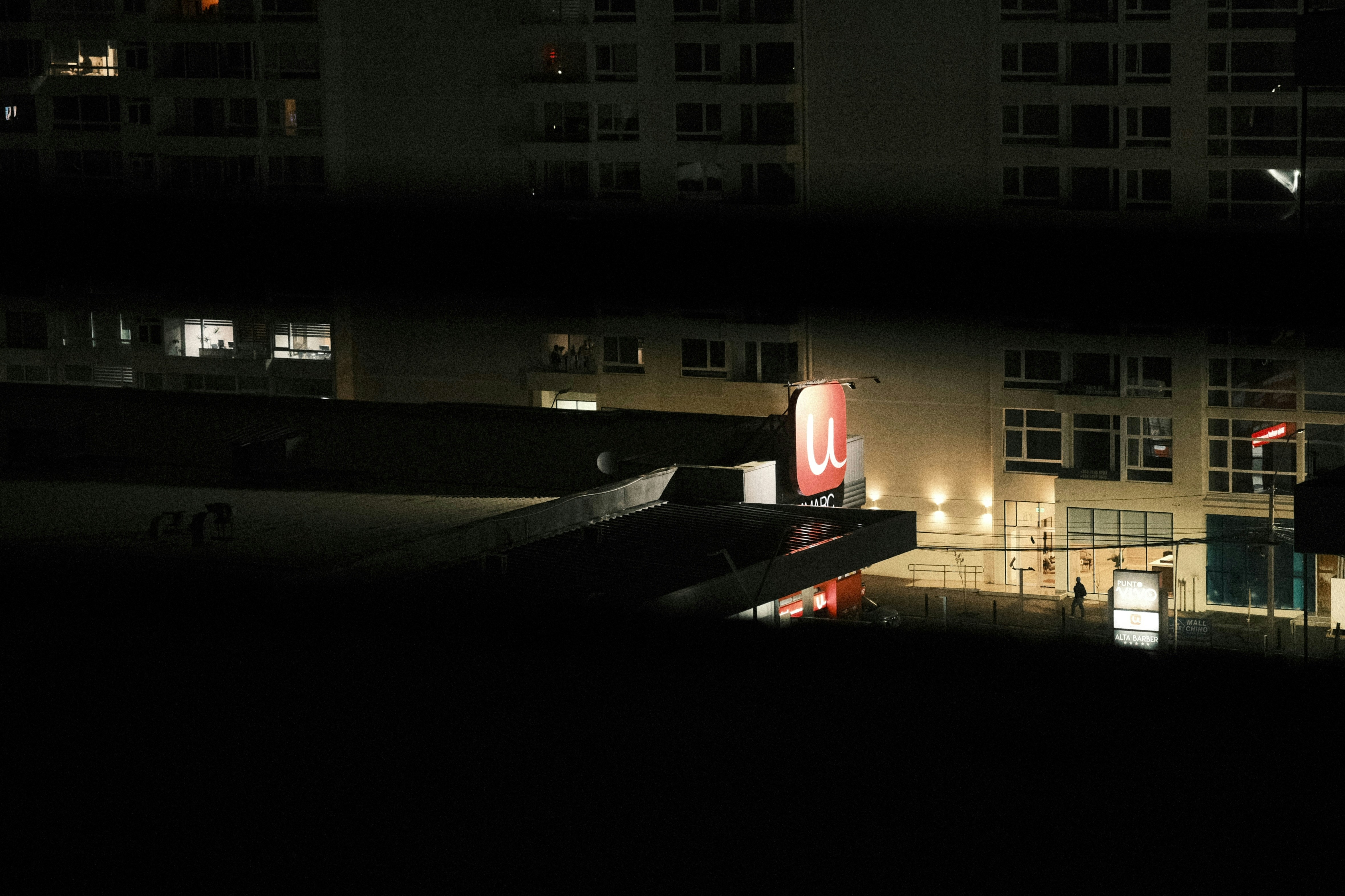 Night Signage Beneath a Dark Rooftop