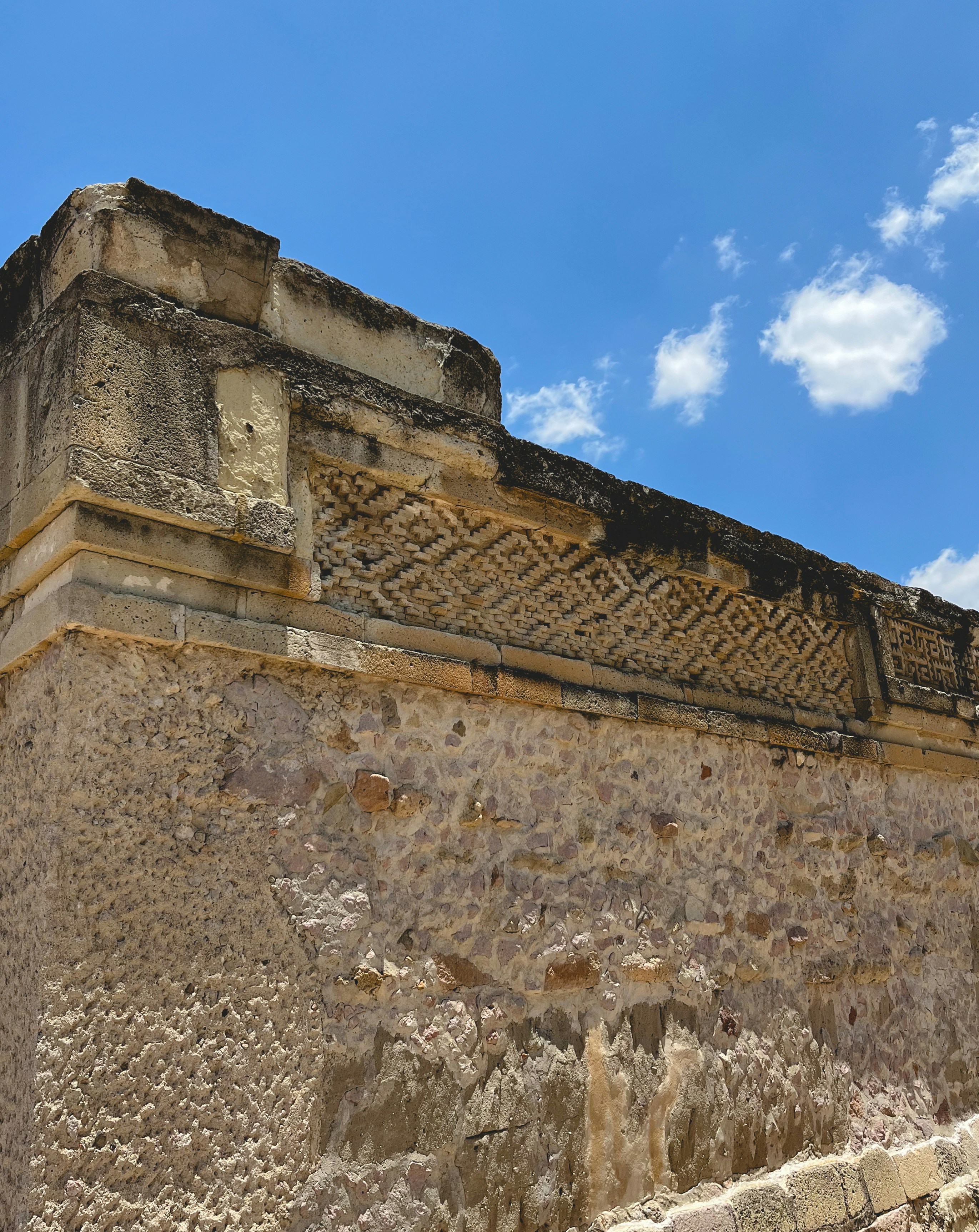 Stonework Echoes: Weathered Frieze Above a Roughened Wall