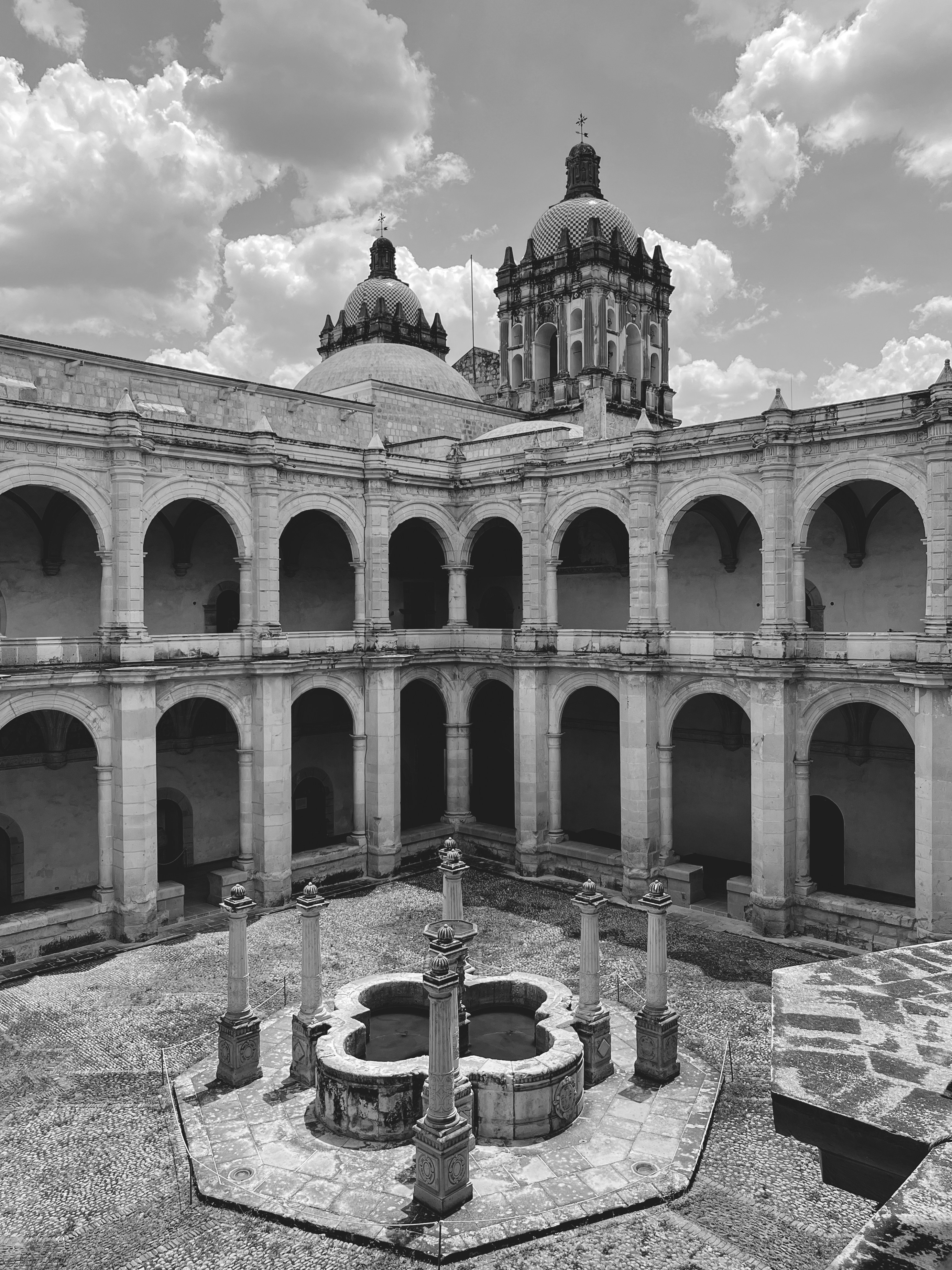 Courtyard of Arches and Fountains Under a Clouded Sky