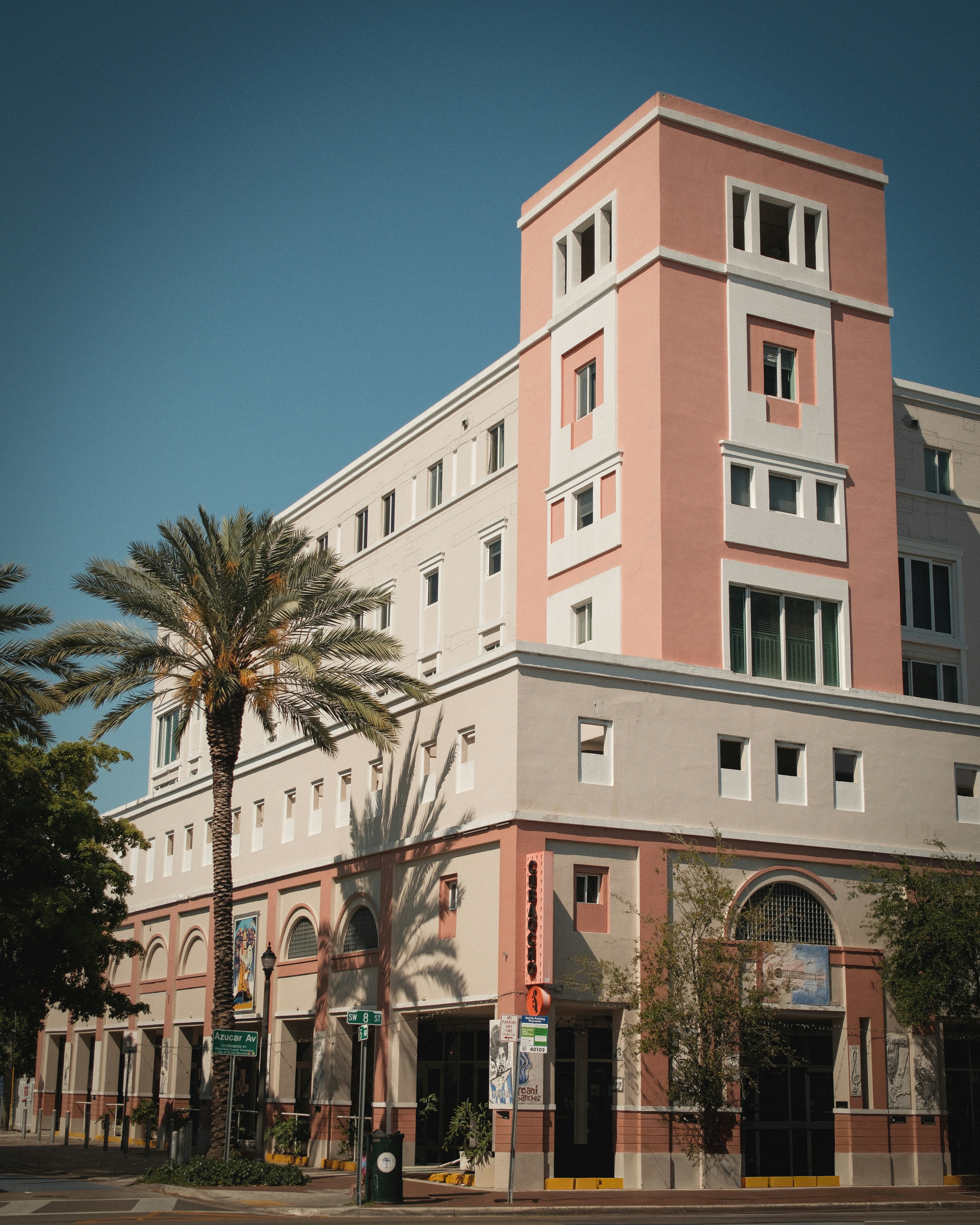 Suncharged Facade: A Corner-Towered Urban Hotel Rising Over Palm Shadows