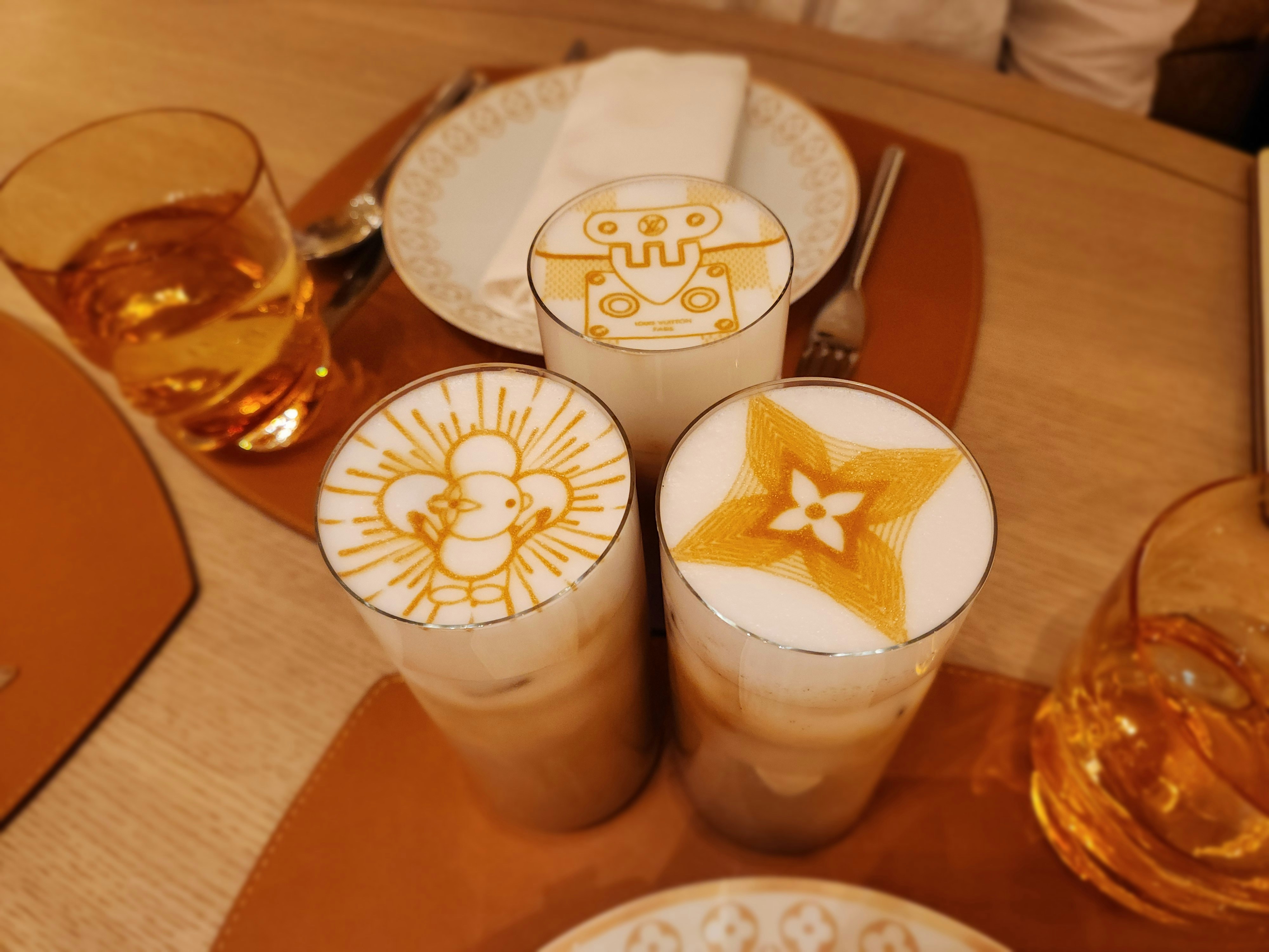 Latte Art Parade: Three Foamy Faces Under Warm Ambience