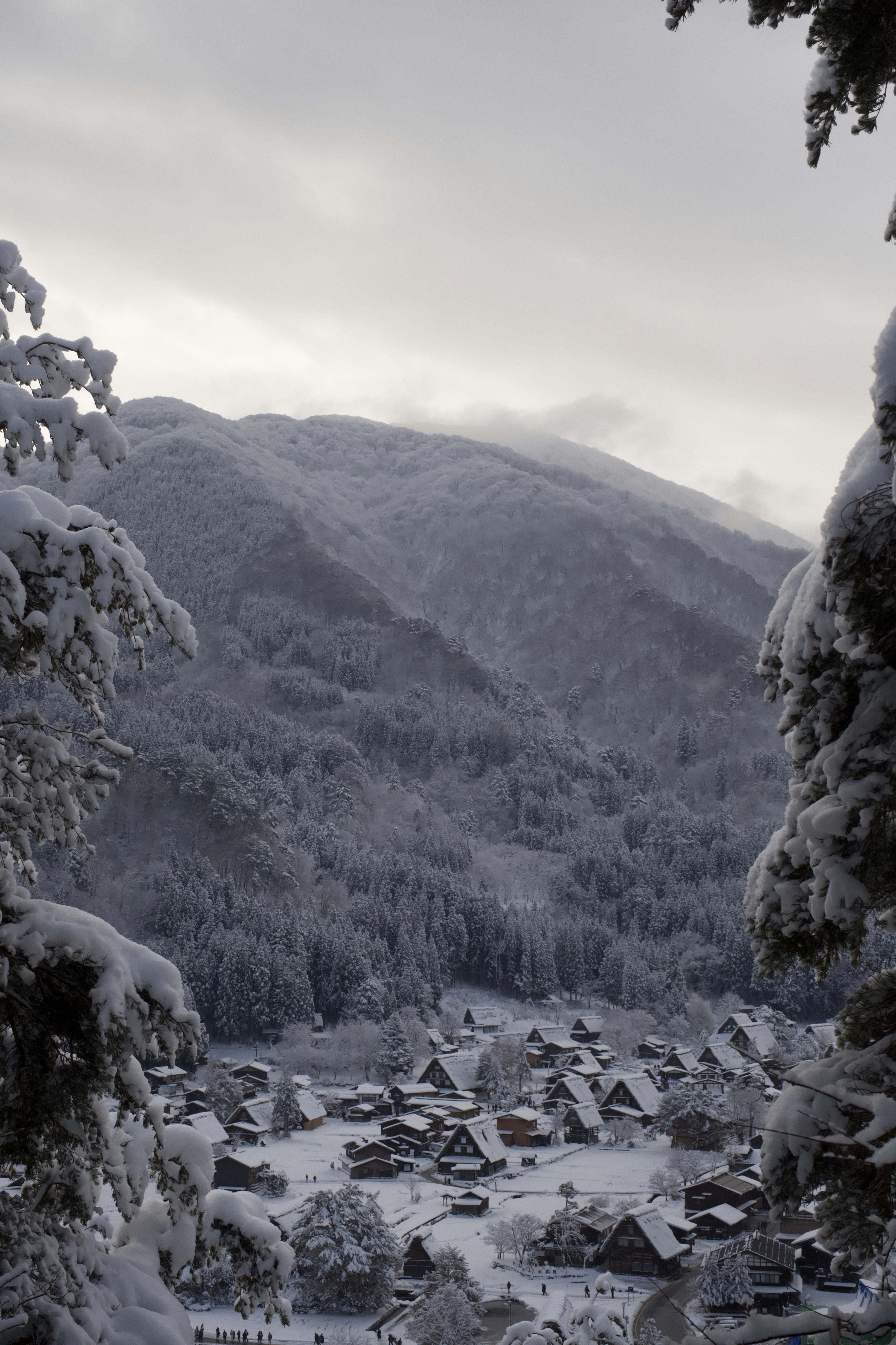 A snow-covered village nestled in a valley surrounded by mountains.