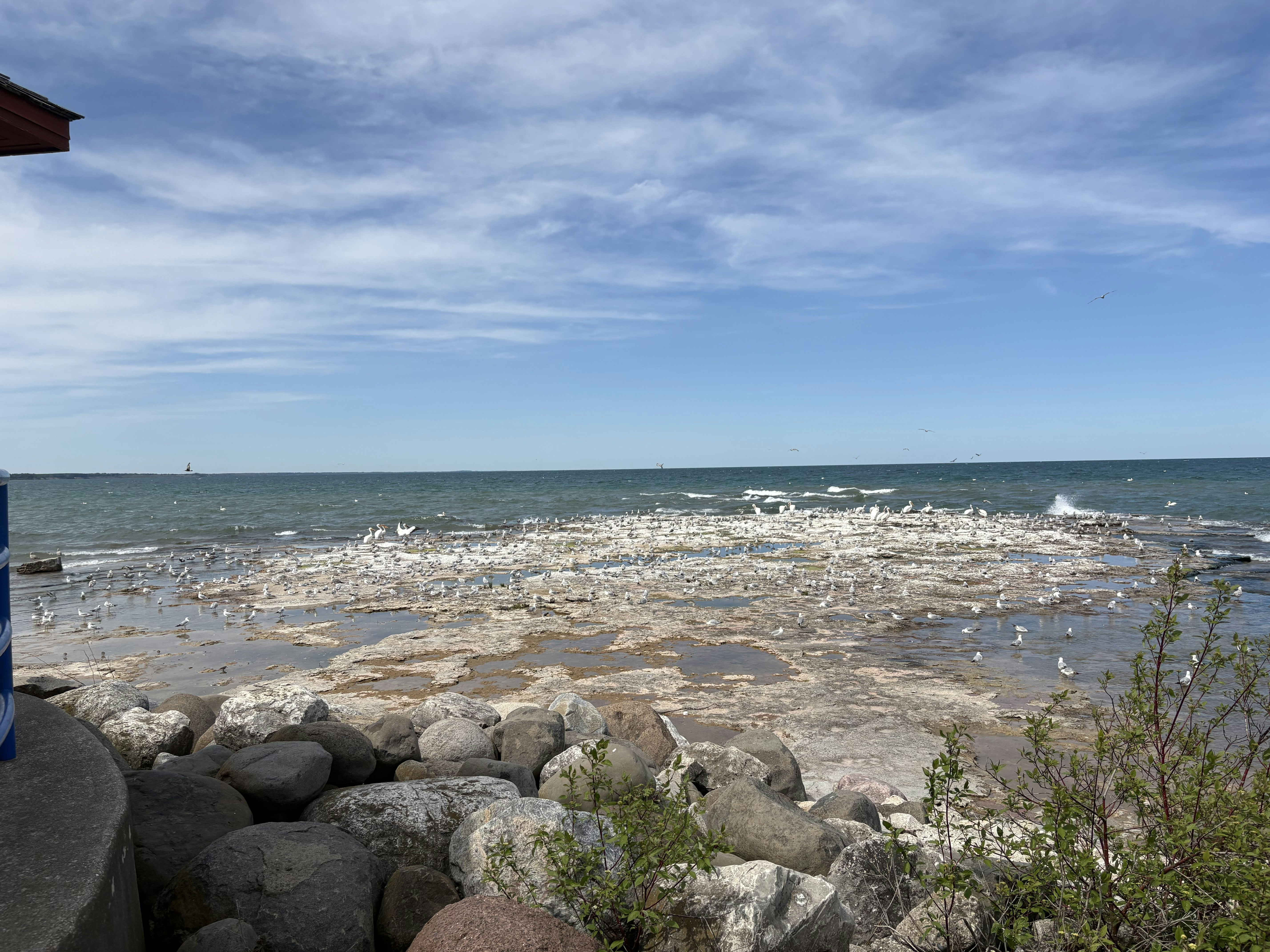 Rugged shoreline confluence: stones, surf, and open horizon