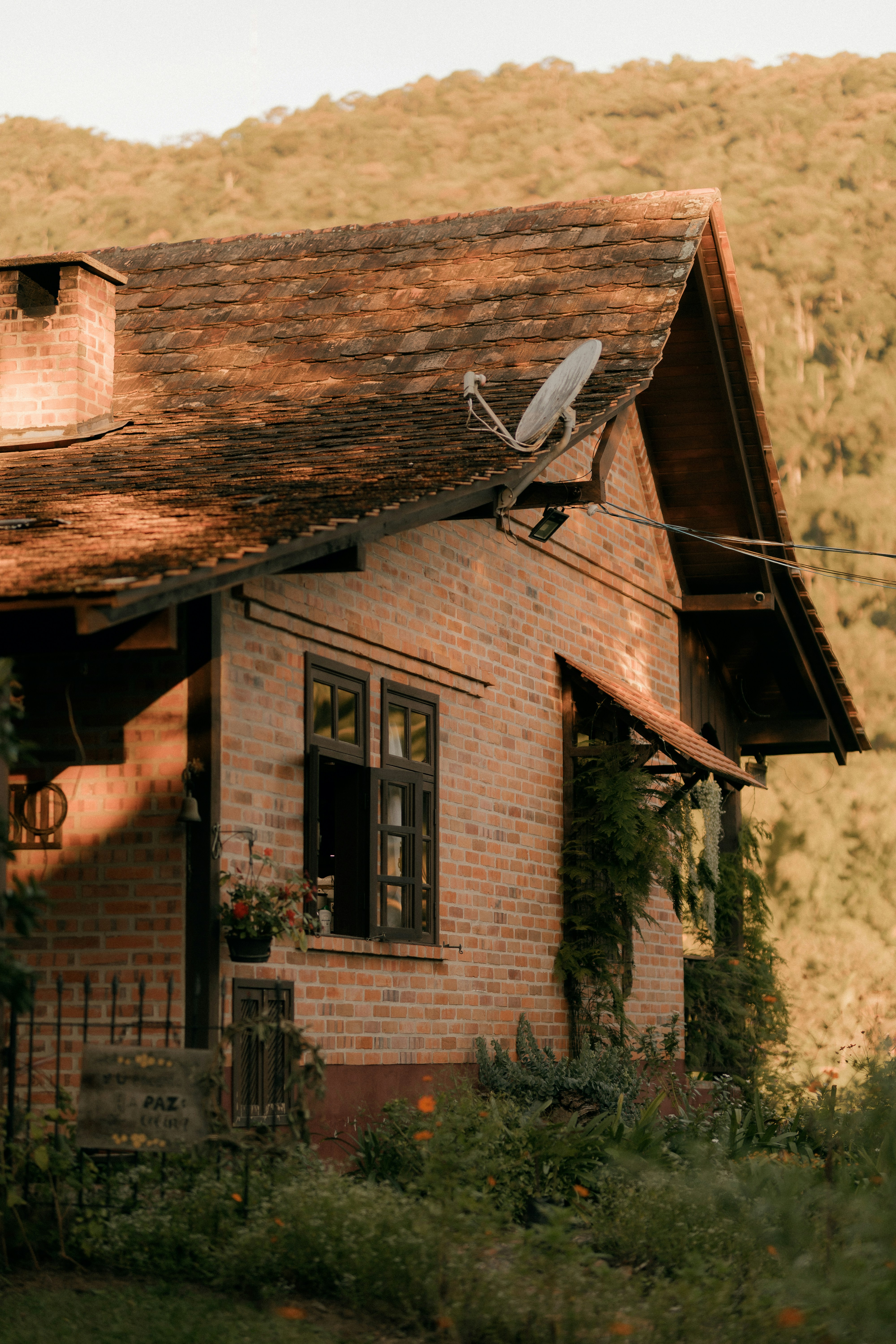 Amber Light on Brick Gable: A Quiet Rural Roofscape