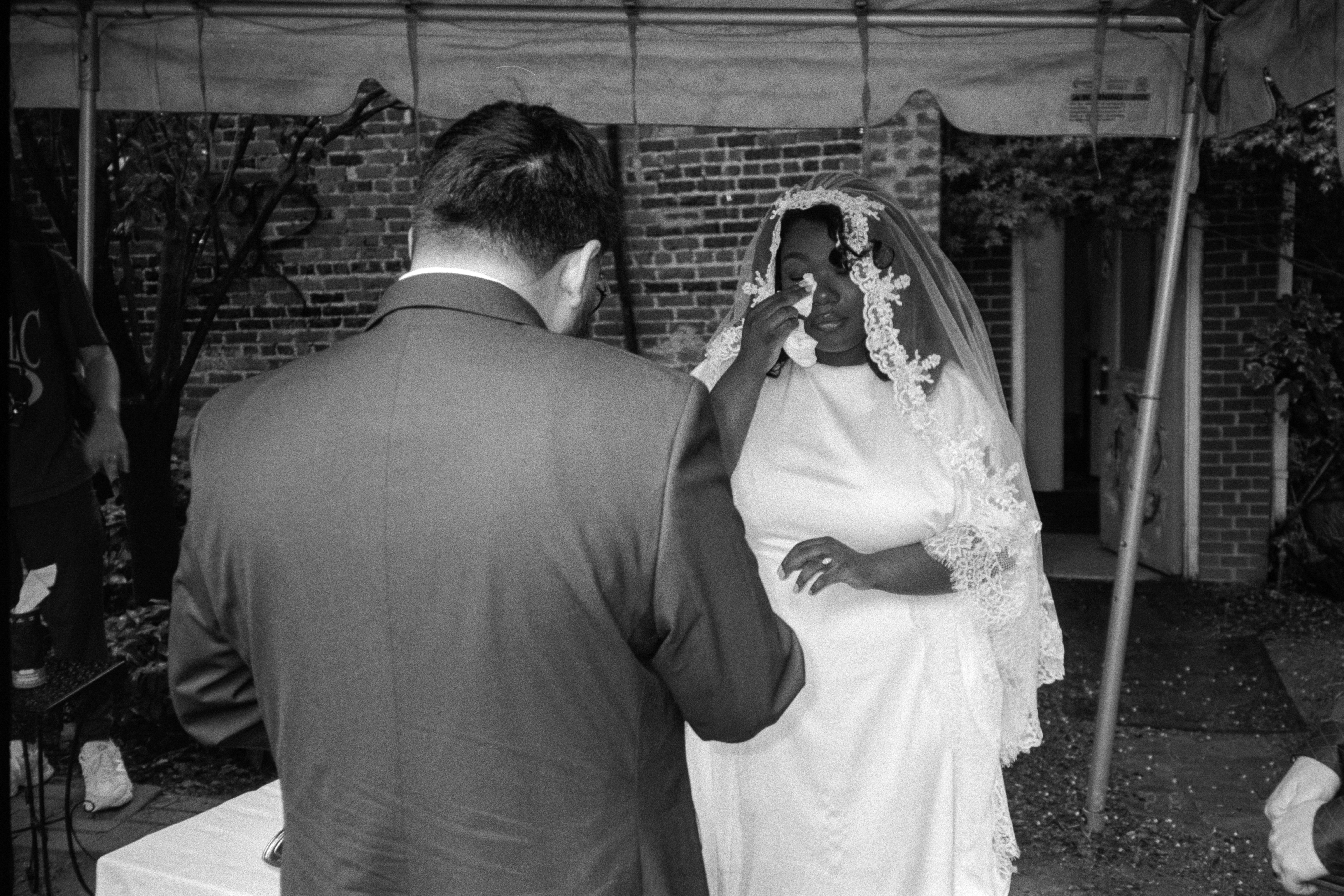Crying bride in wedding dress with man.