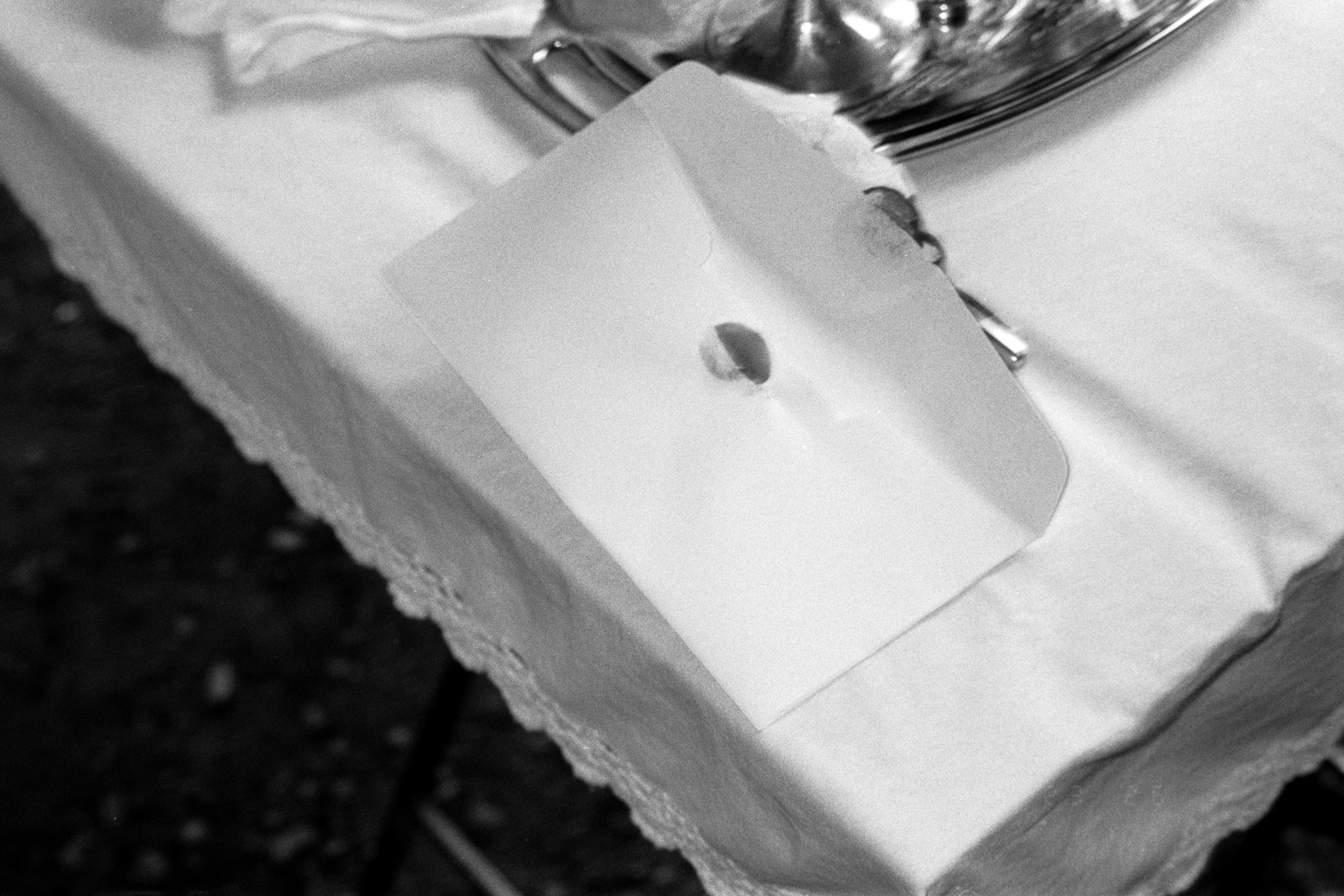 White paper envelope with small object on a lace tablecloth.