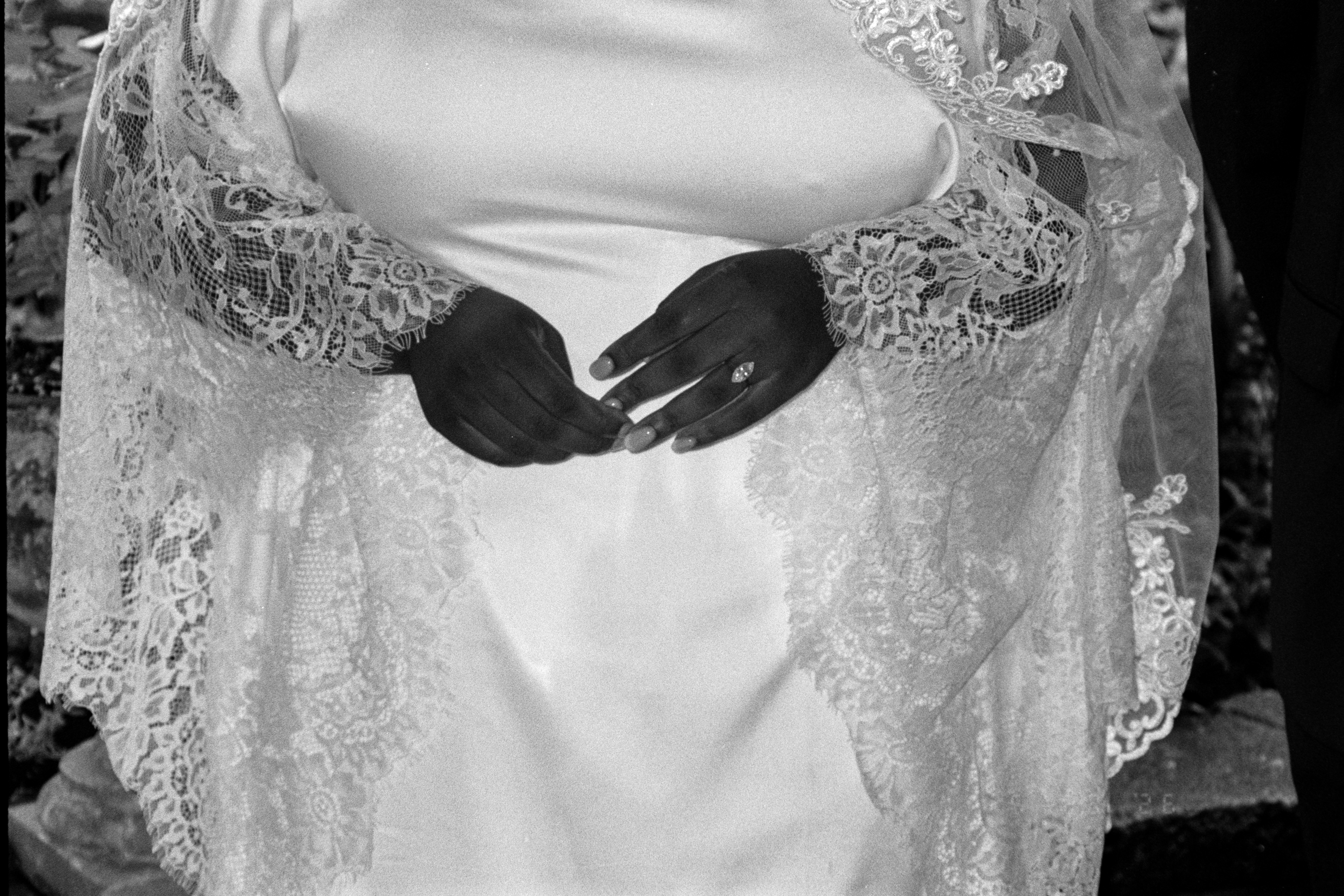 Handful of Grace: Diamond Ring Between Lace-Wrapped Hands