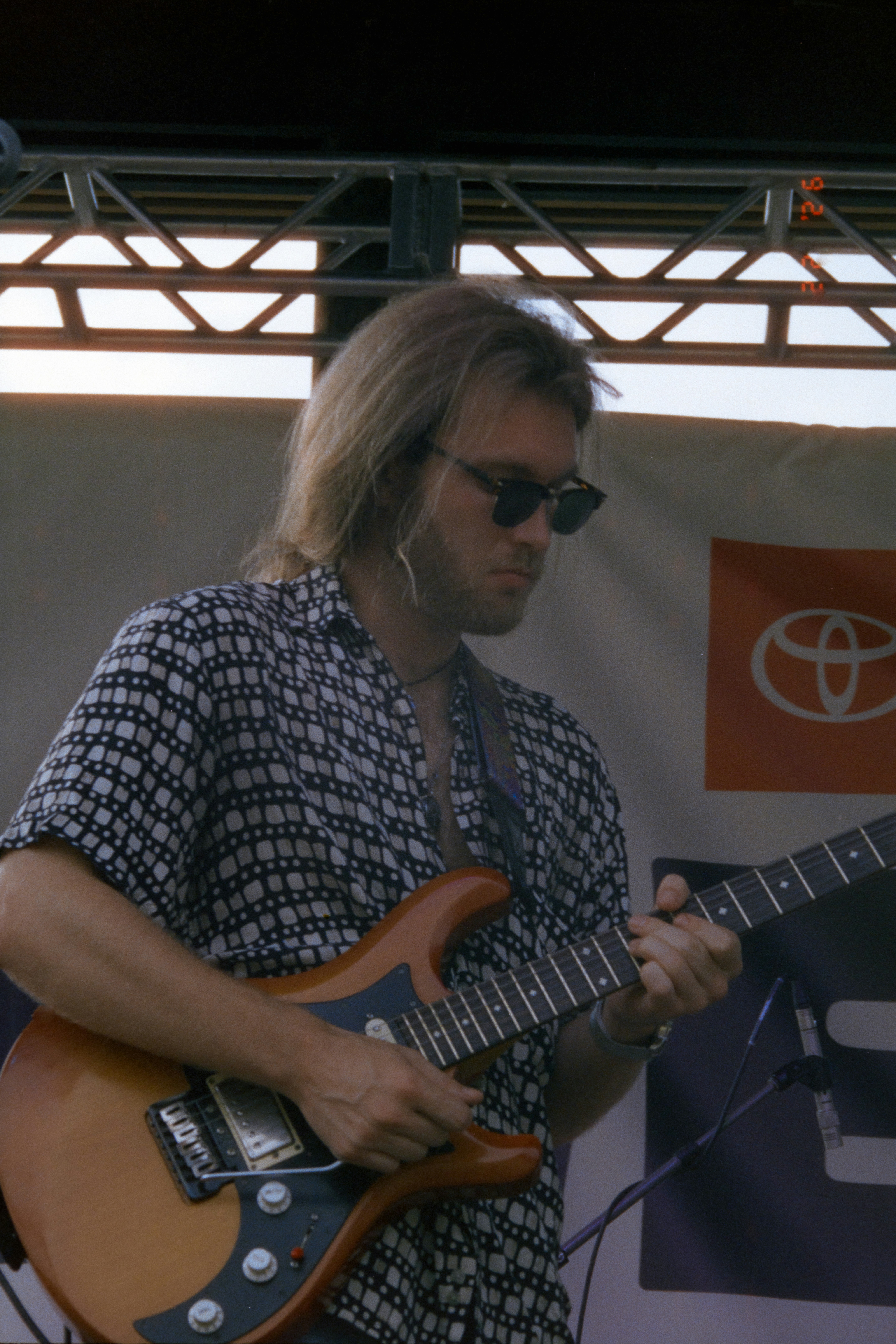 Sunlit Strings: A Guitarist in a Checker-Print Moment