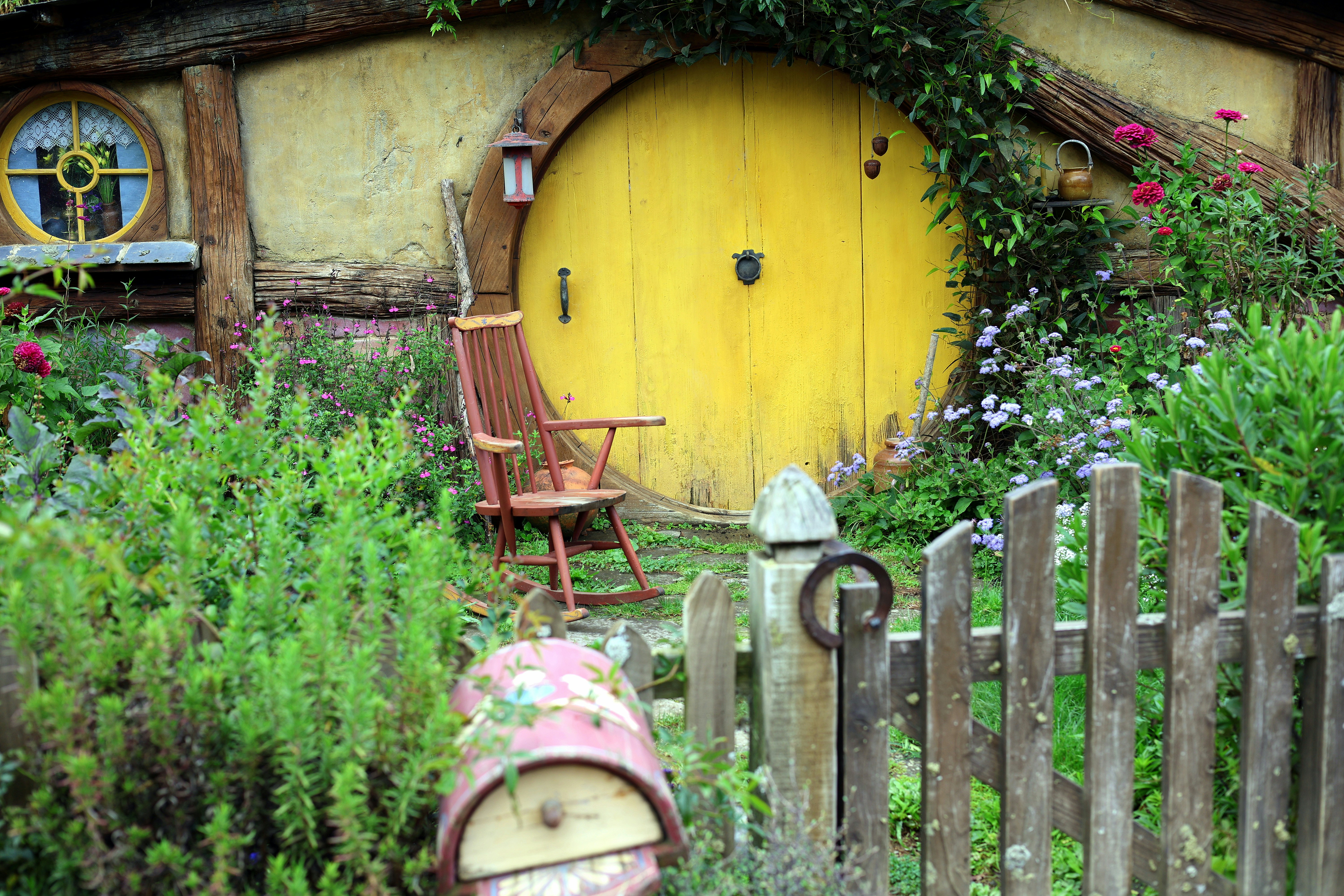 A Round Yellow Door in a Cottage with Lush Garden