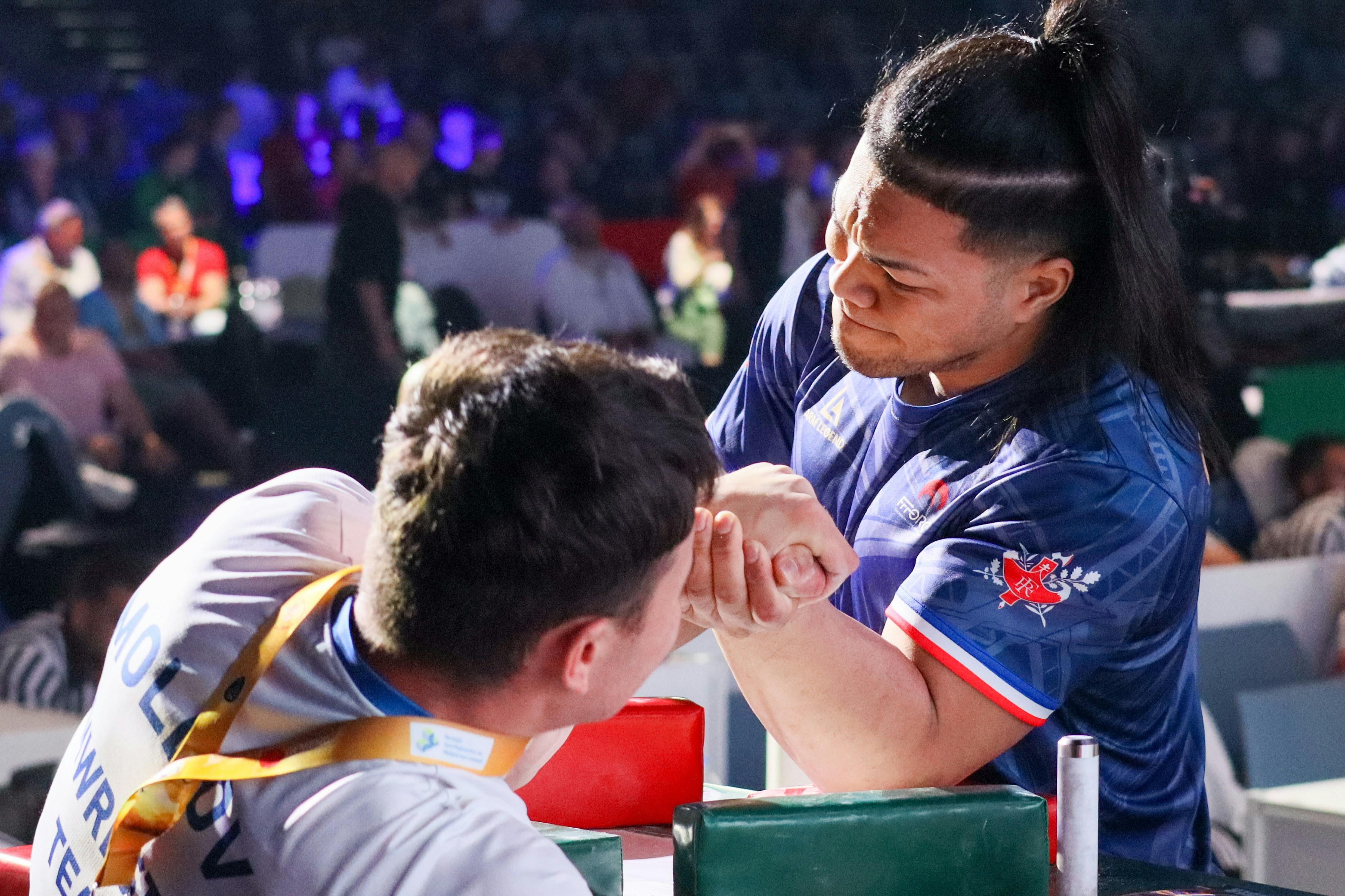 Intense arm wrestling match between two focused competitors.