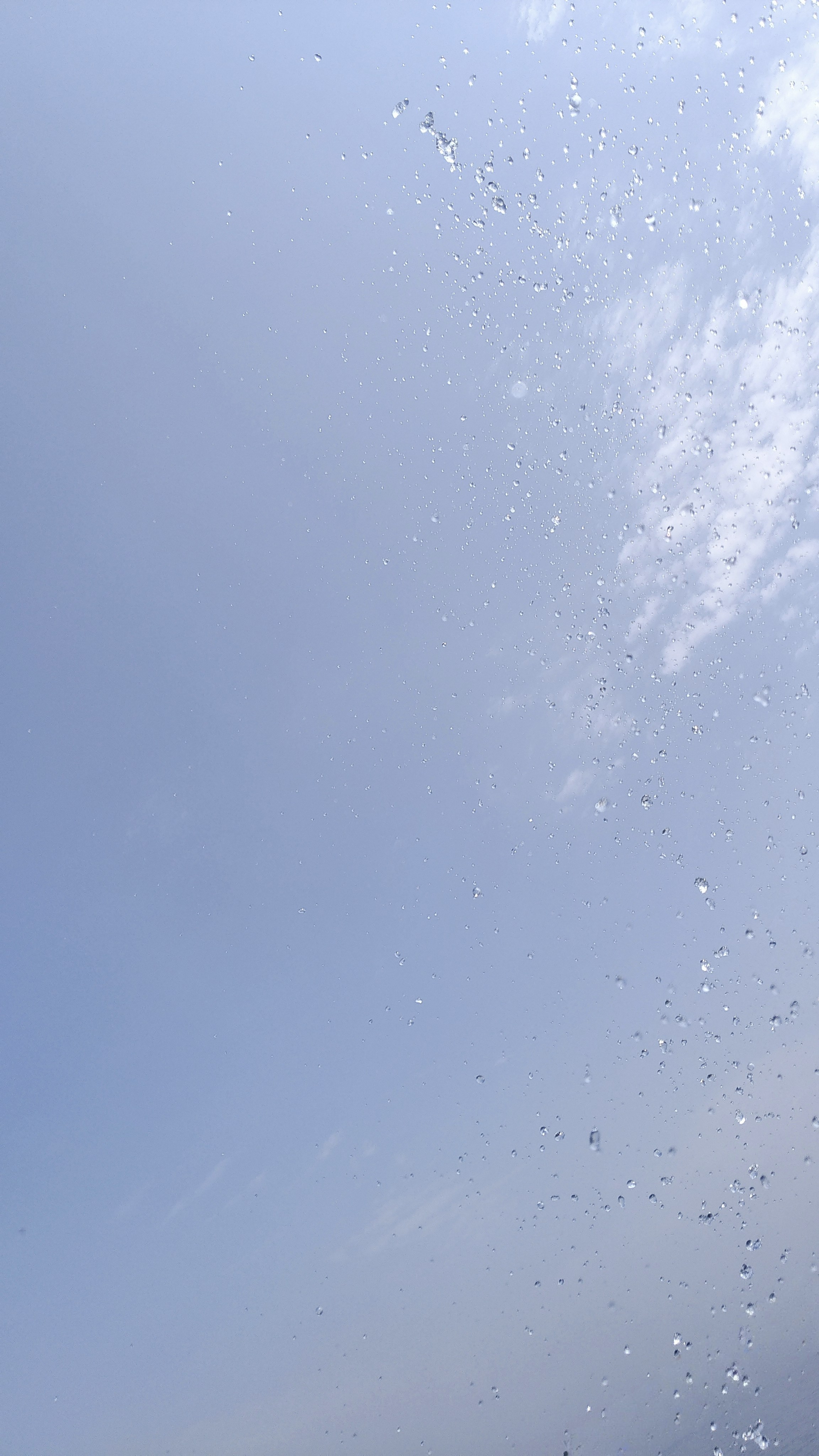 Sky Charge: Cascading Droplets Against a Clear Blue Canopy
