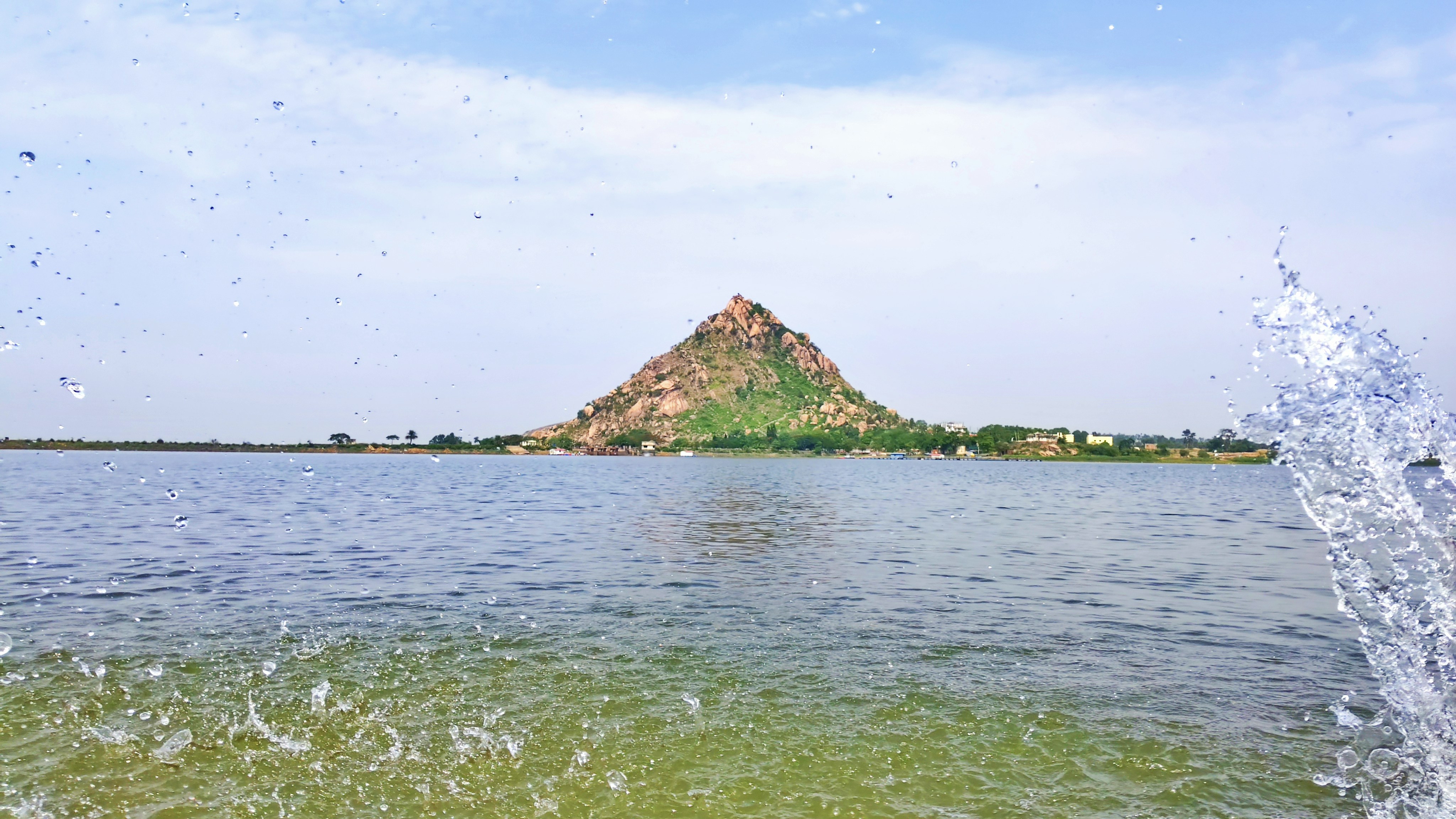 A Lone Hill Rising from the Lake — Calm Waters and a Splashy Foreground