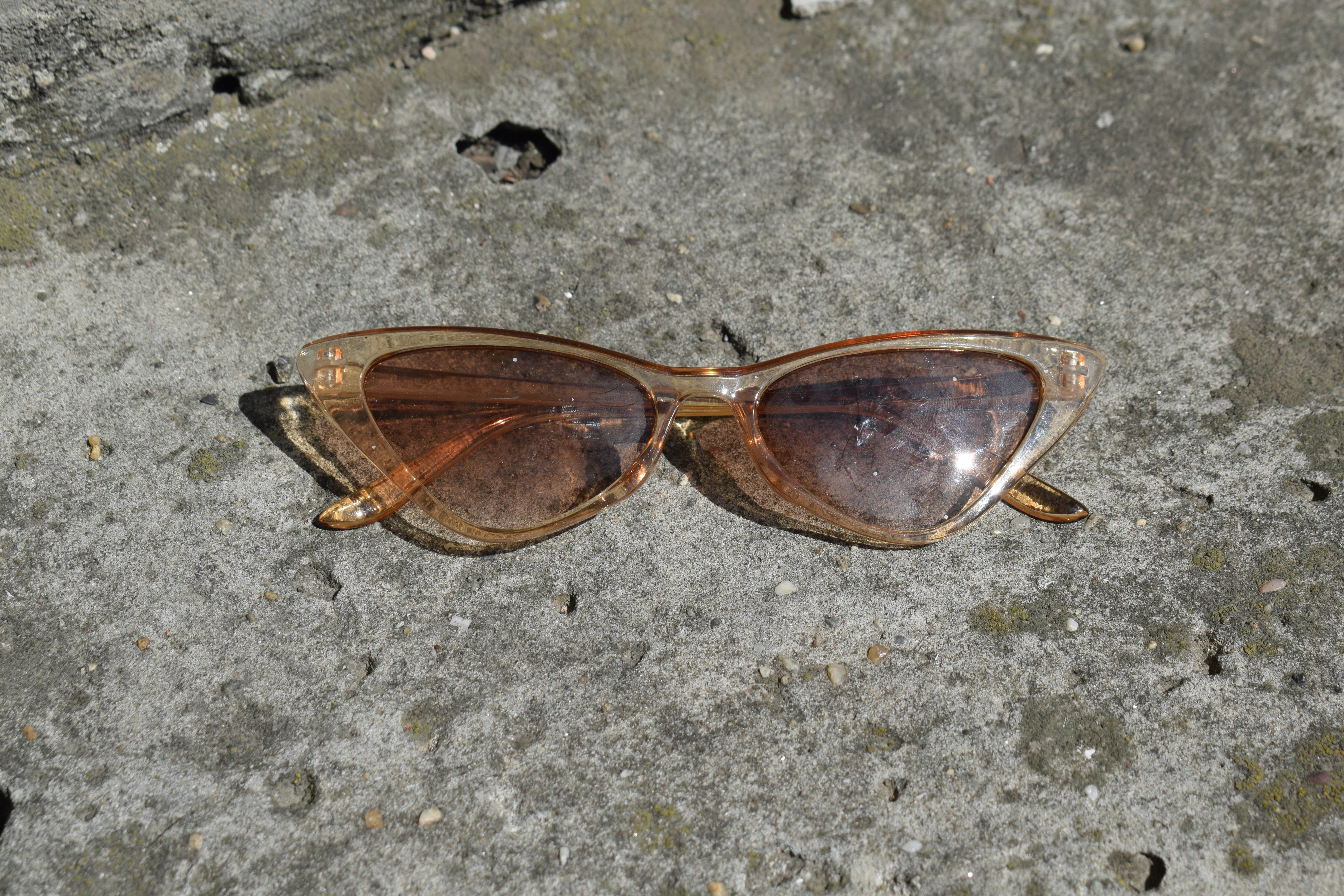 Worn Sunglasses Resting on Weathered Concrete