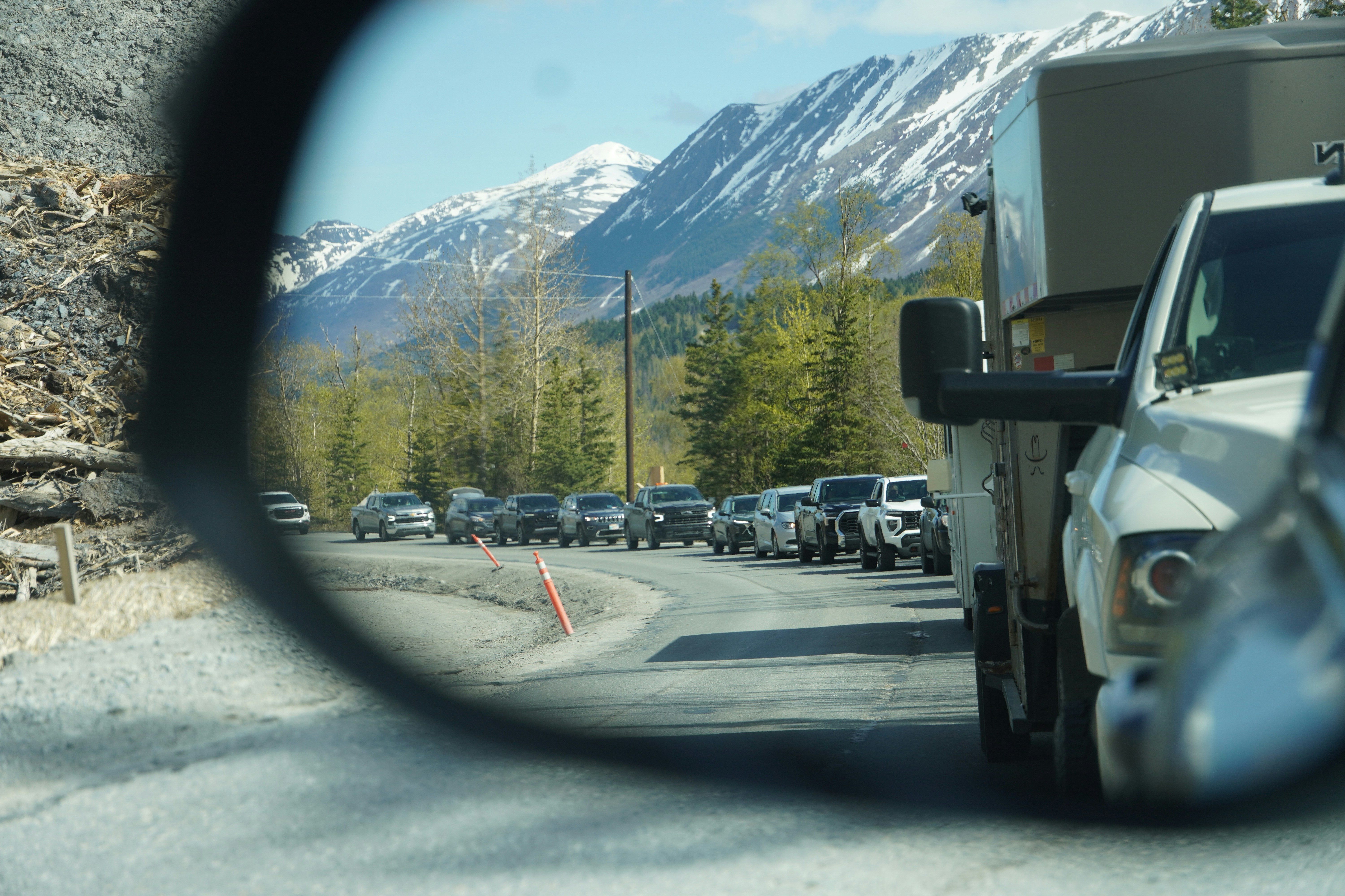 Rearview Roadblock: Snowy Peaks Framed by Traffic Line