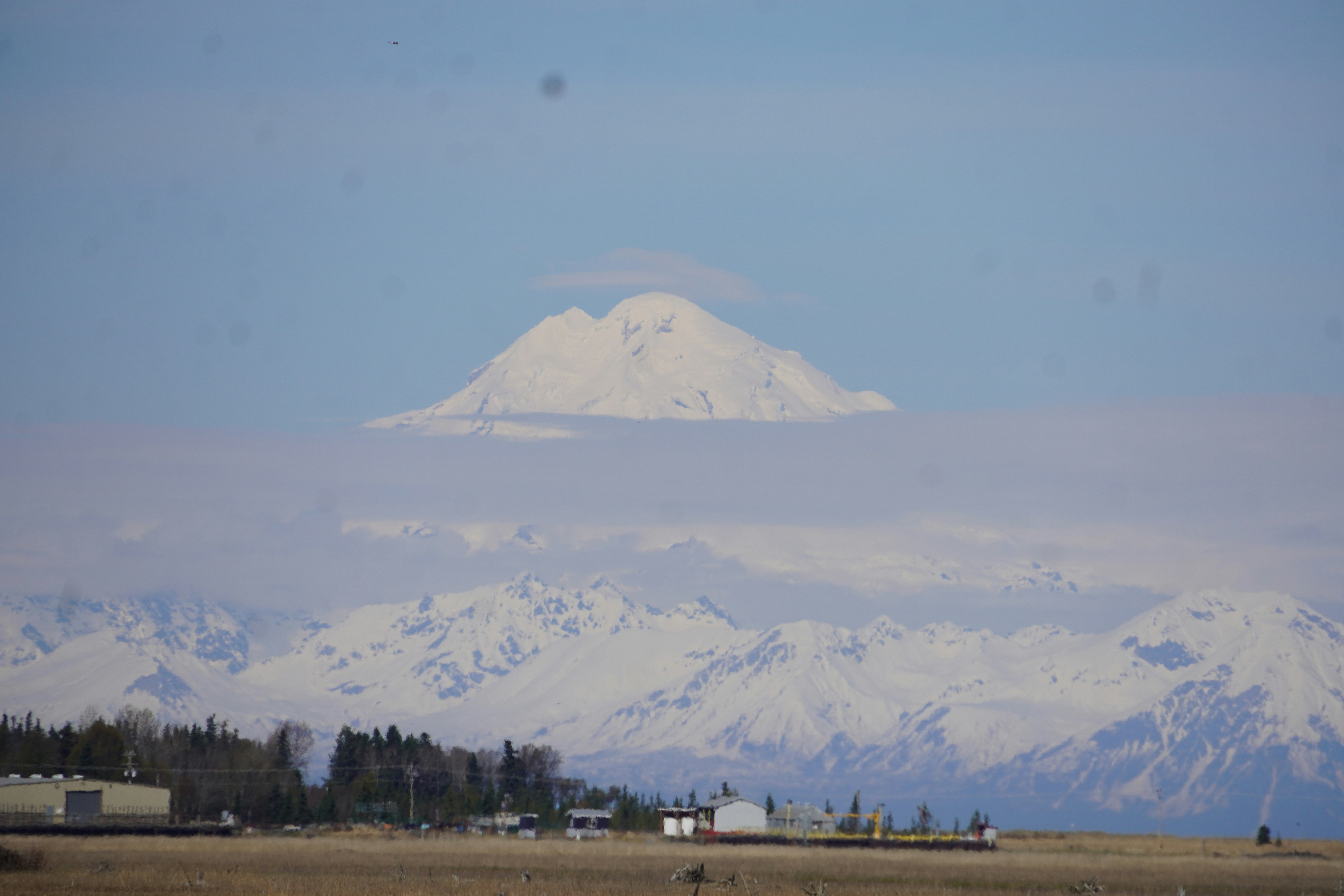 Snow Crowned Peak Rising Above Prairie Horizon