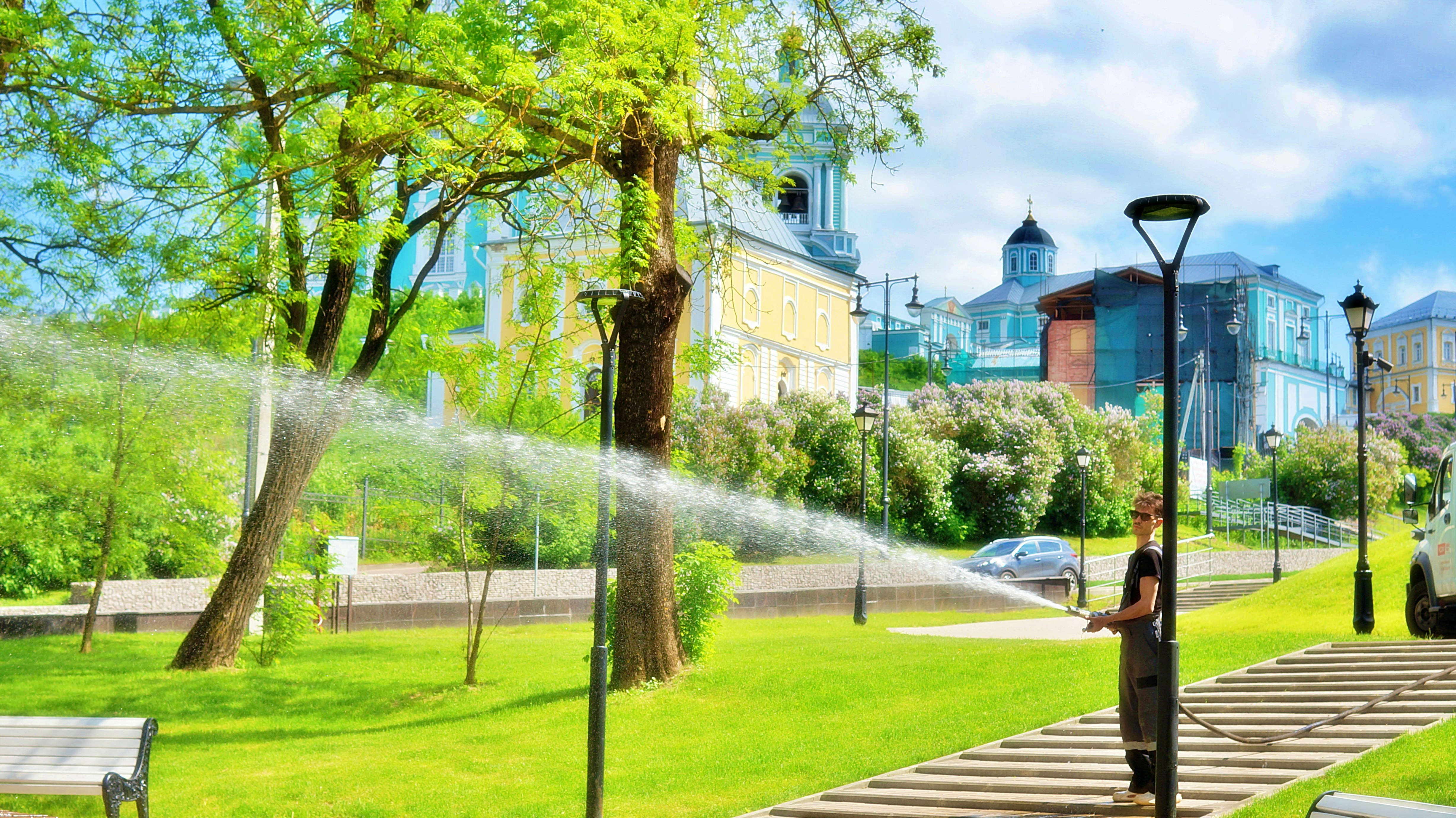 Sprinkler Arc Over a Sunlit City Park