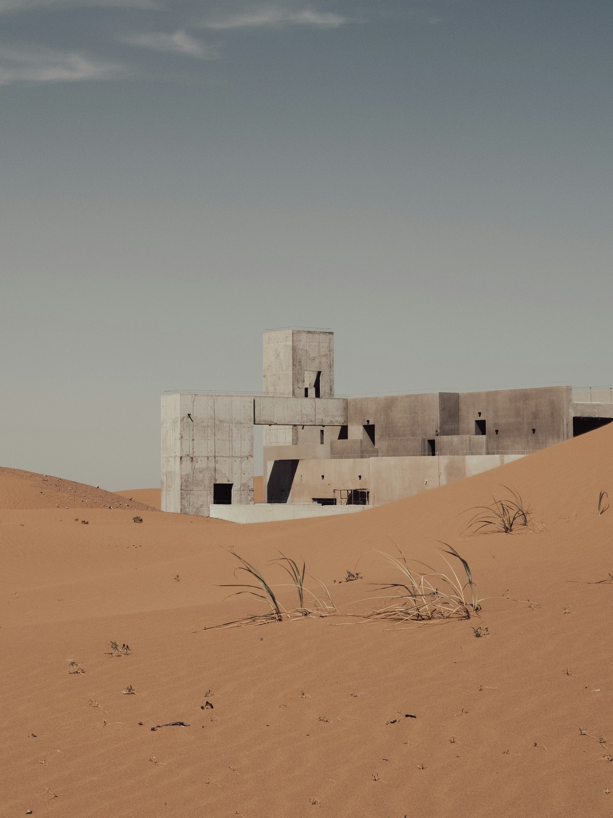 Concrete building in a desert under a clear sky.