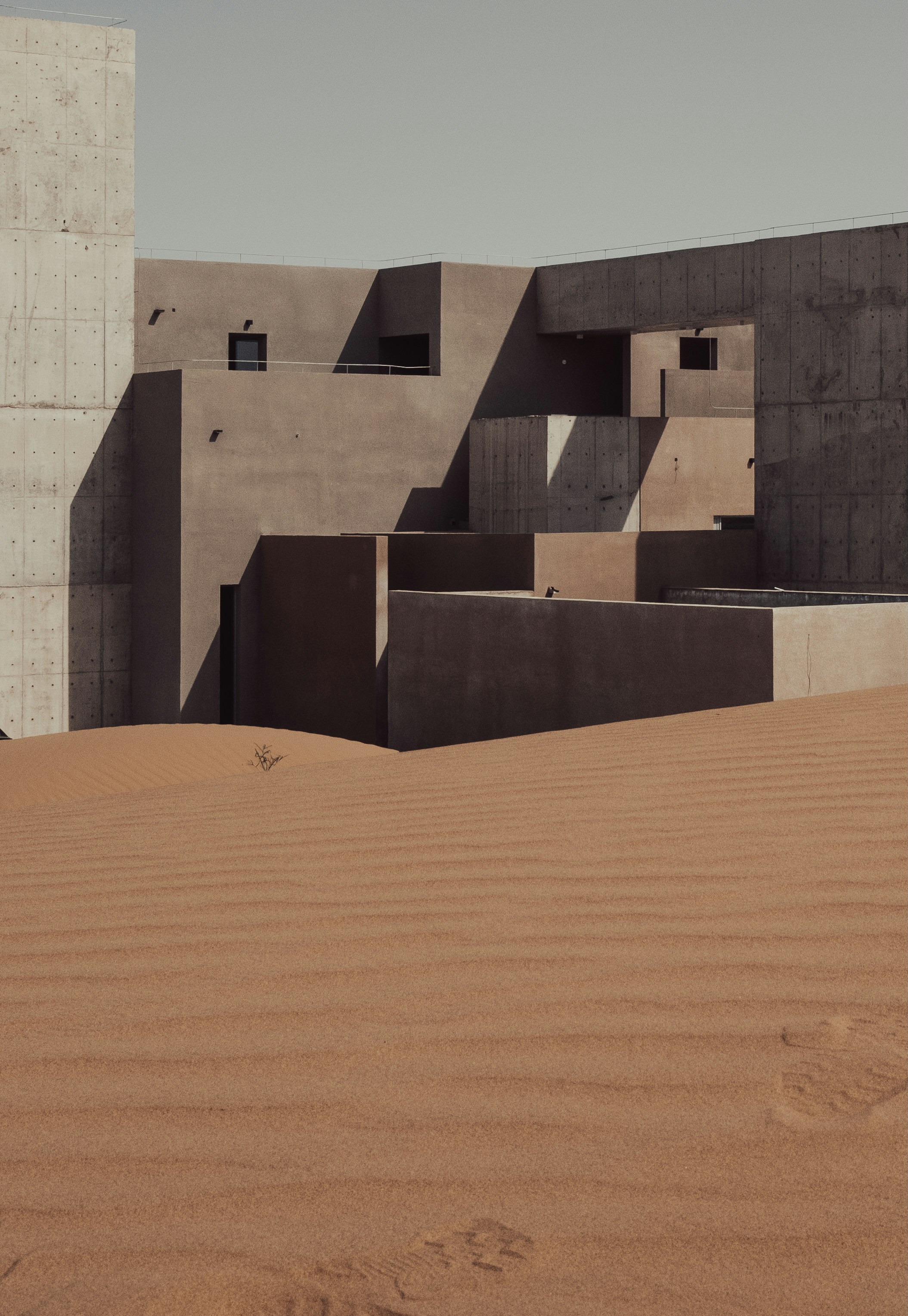 Desert Geometry: Concrete Fortresses Against Golden Dunes