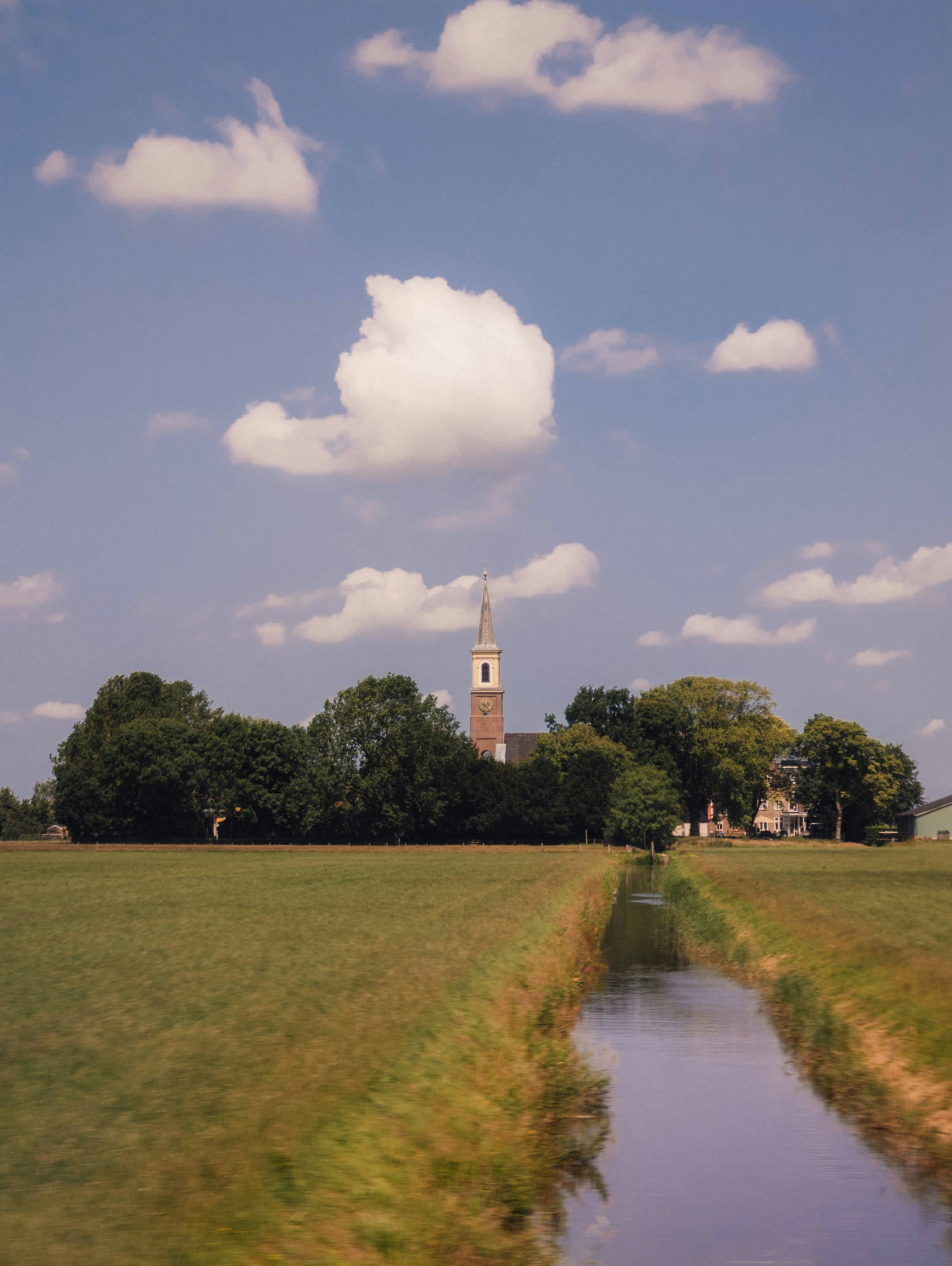 Towered Quiet: A Village Church Stands Along a Narrow Canal