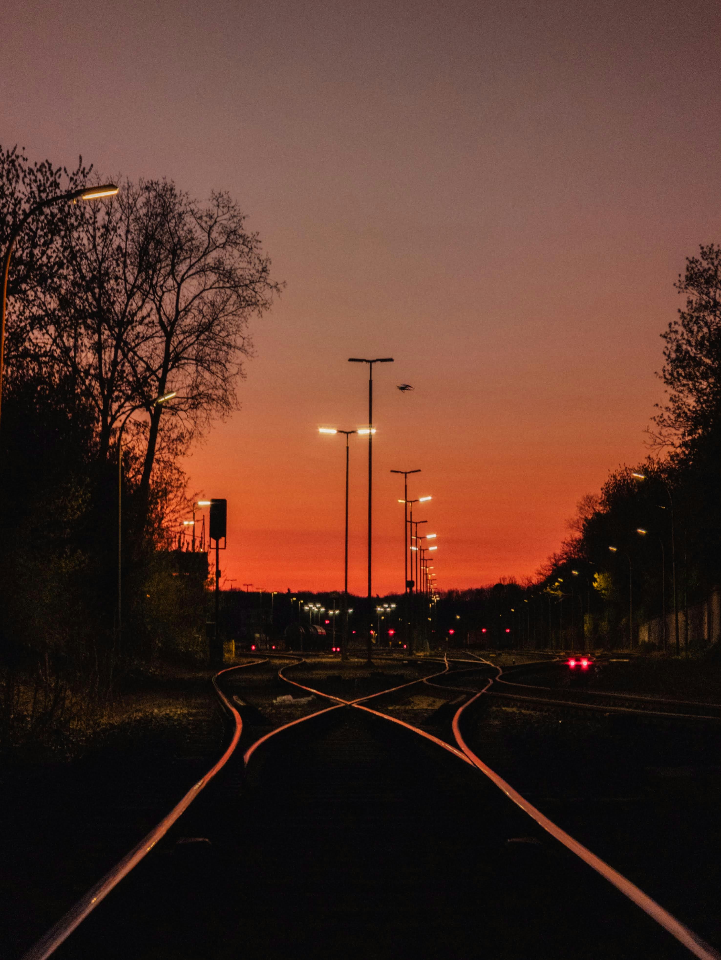 Crossroads at Dusk: Rails Converge Beneath a Fiery Sky