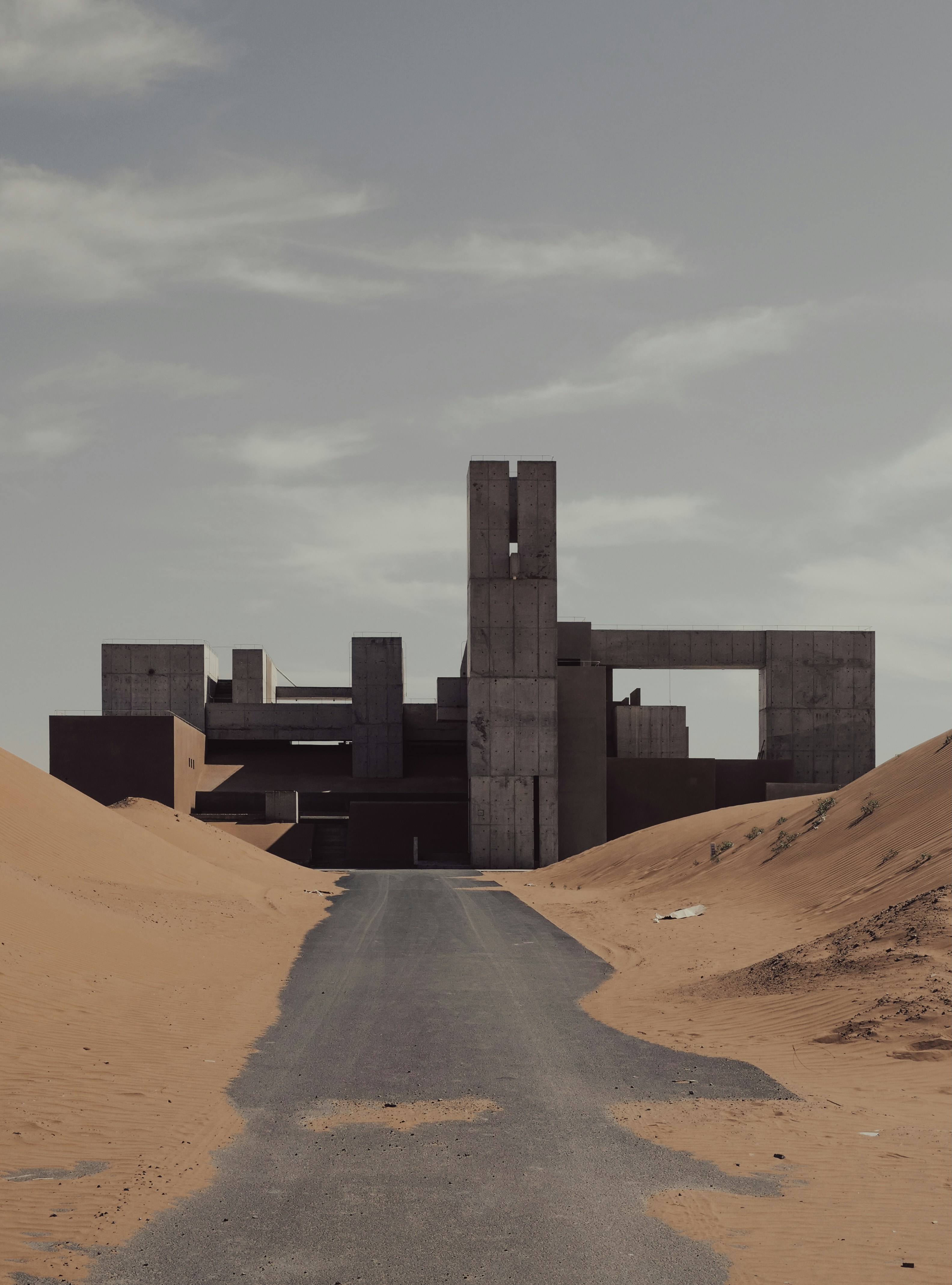 Deserted Monolith: Concrete Skyline Opens Through the Sand