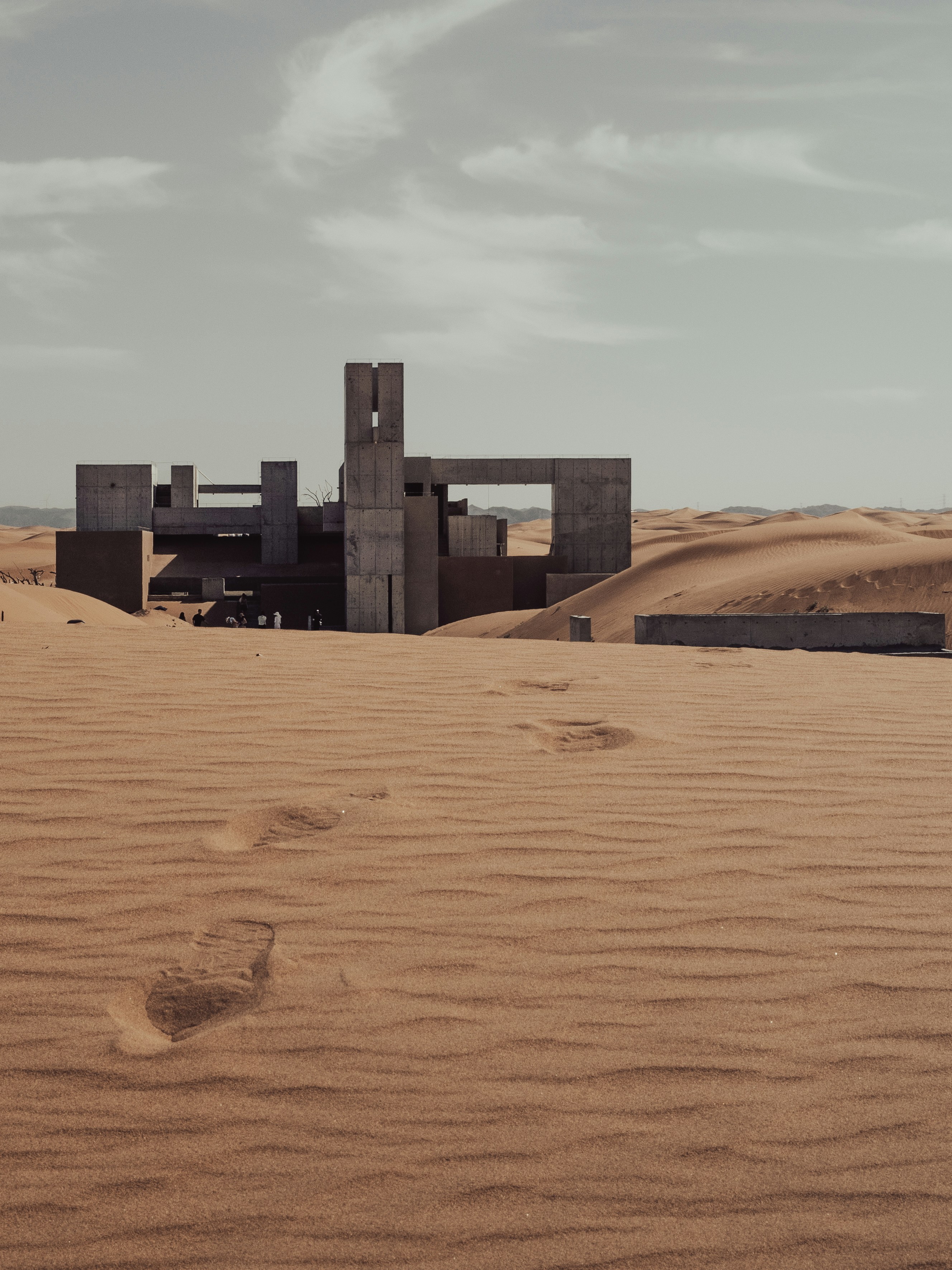 Deserted Monolith: Concrete Ruin Rising from Dune Sea