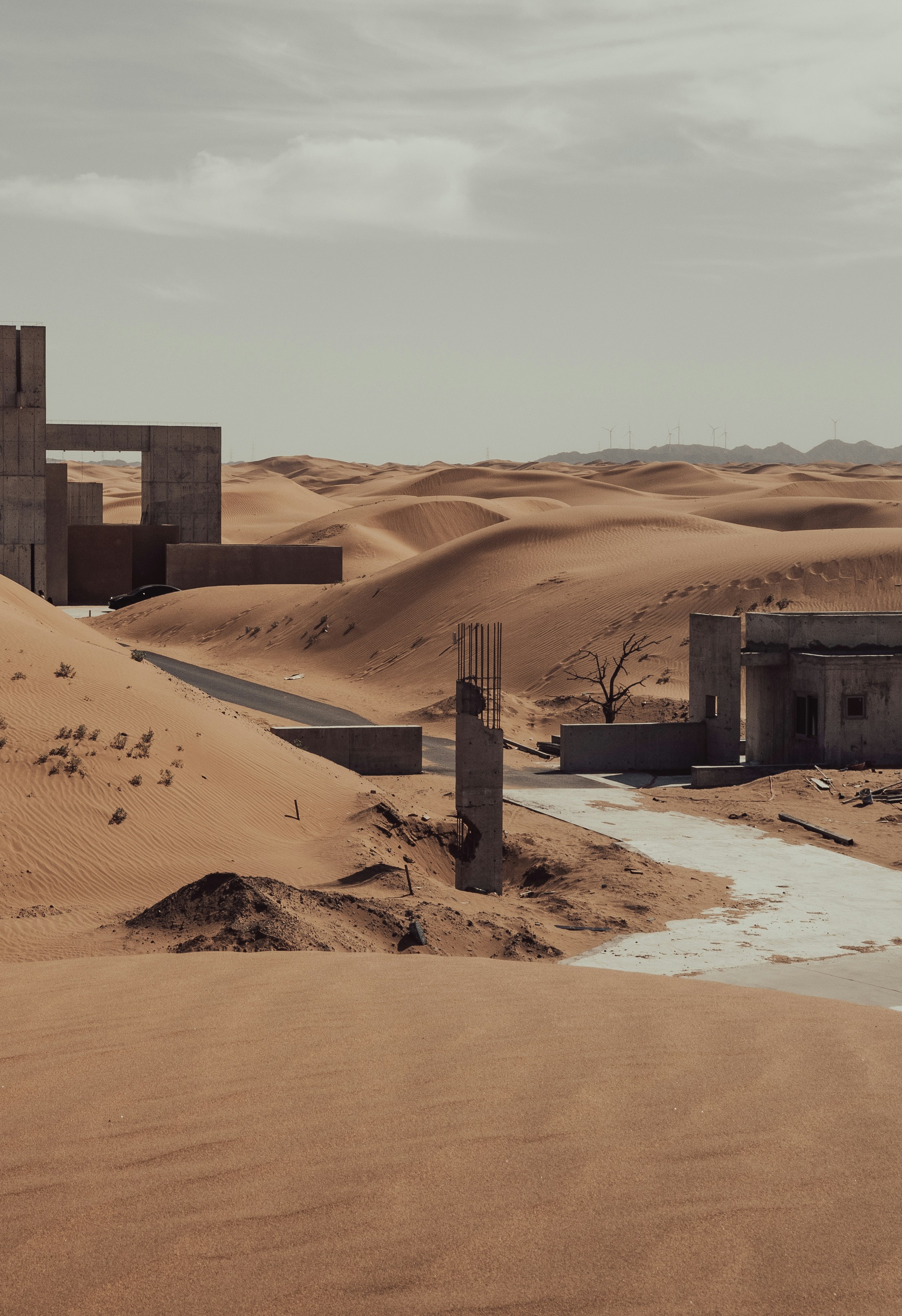 Deserted Monoliths: Concrete Remnants Rise Across Dune Sea
